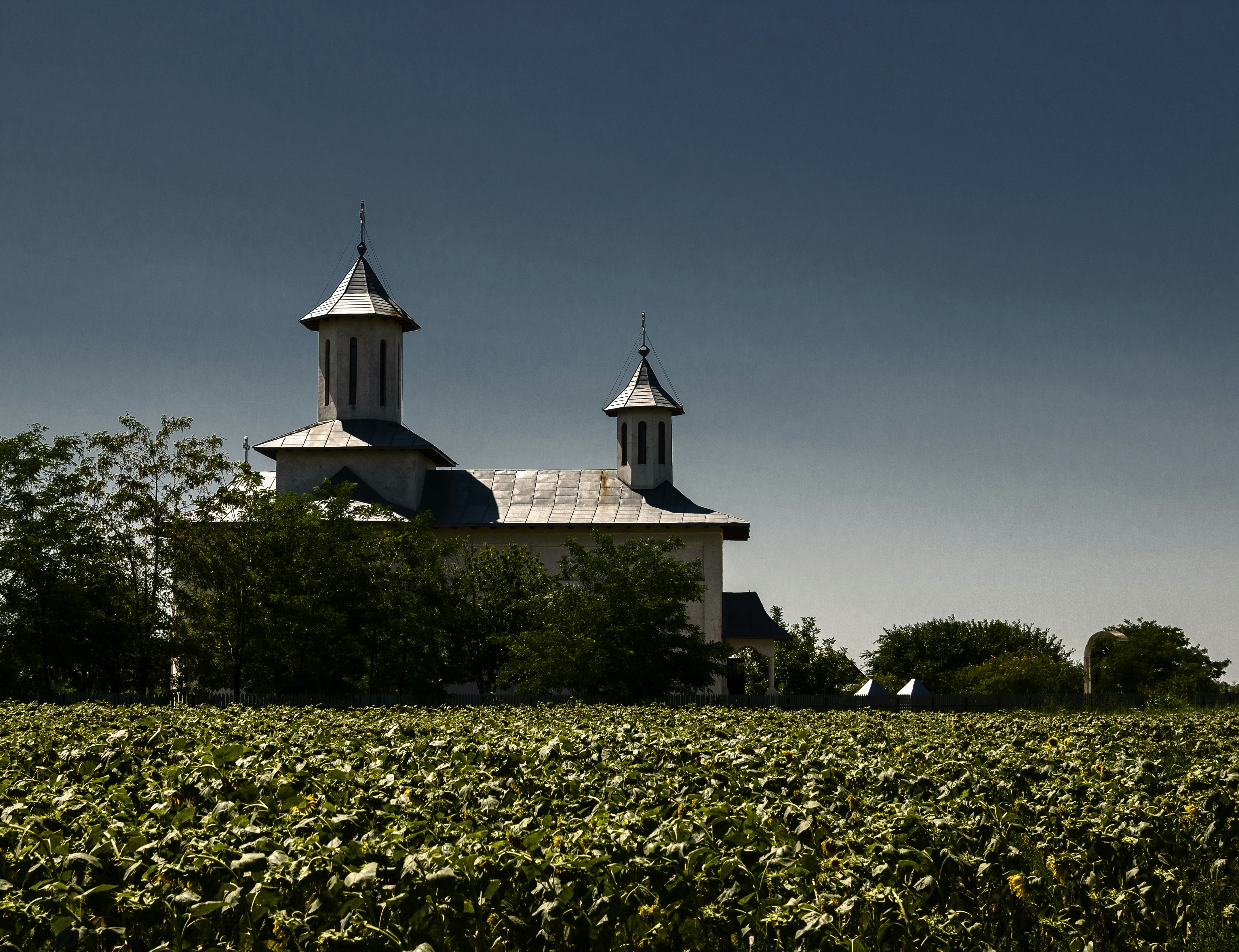 Twin Turrets Over a Quiet Field: A Prairie Farmhouse Beneath a Deep Blue Sky