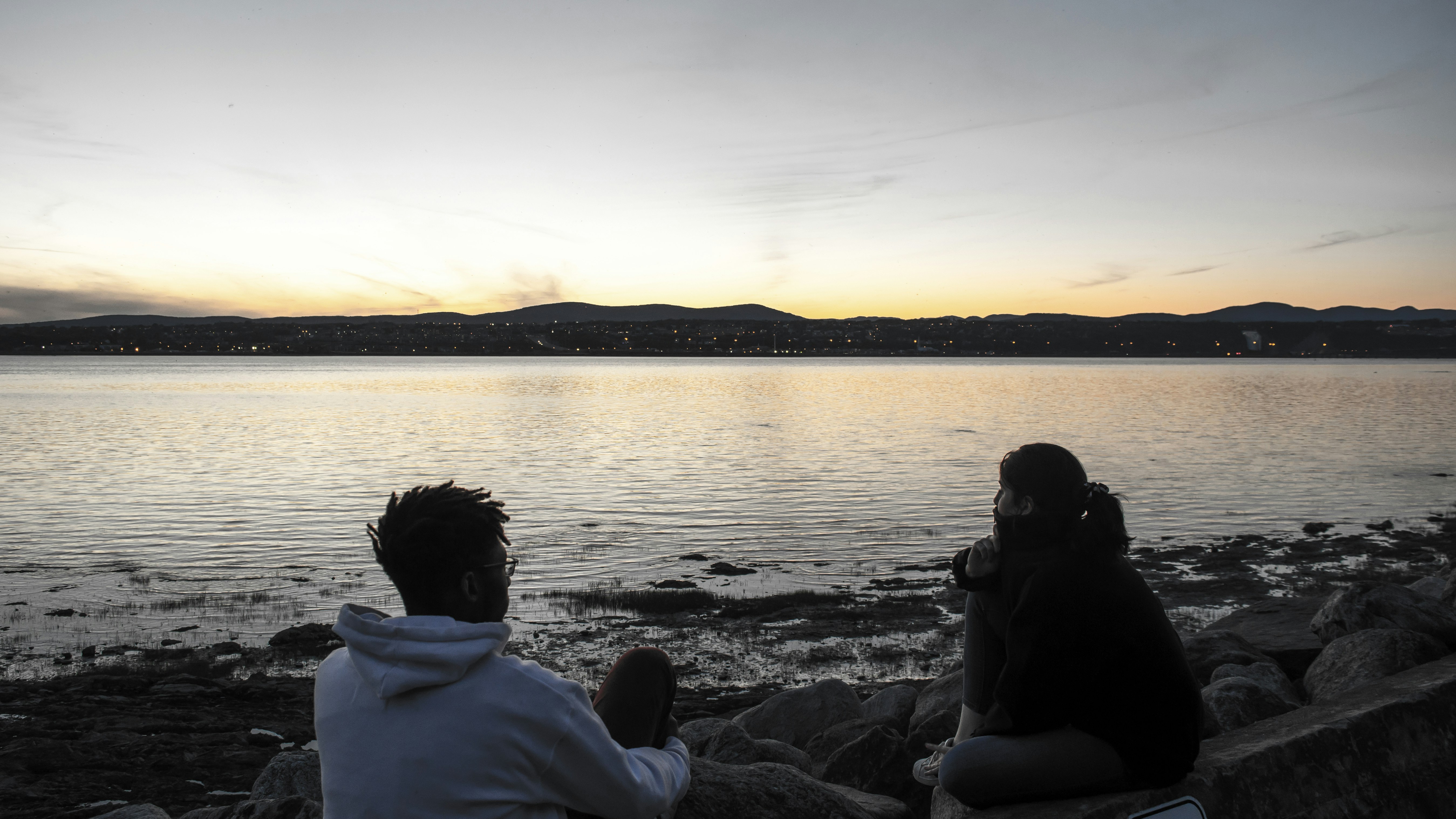 Quiet Conversation by the Water at Dusk