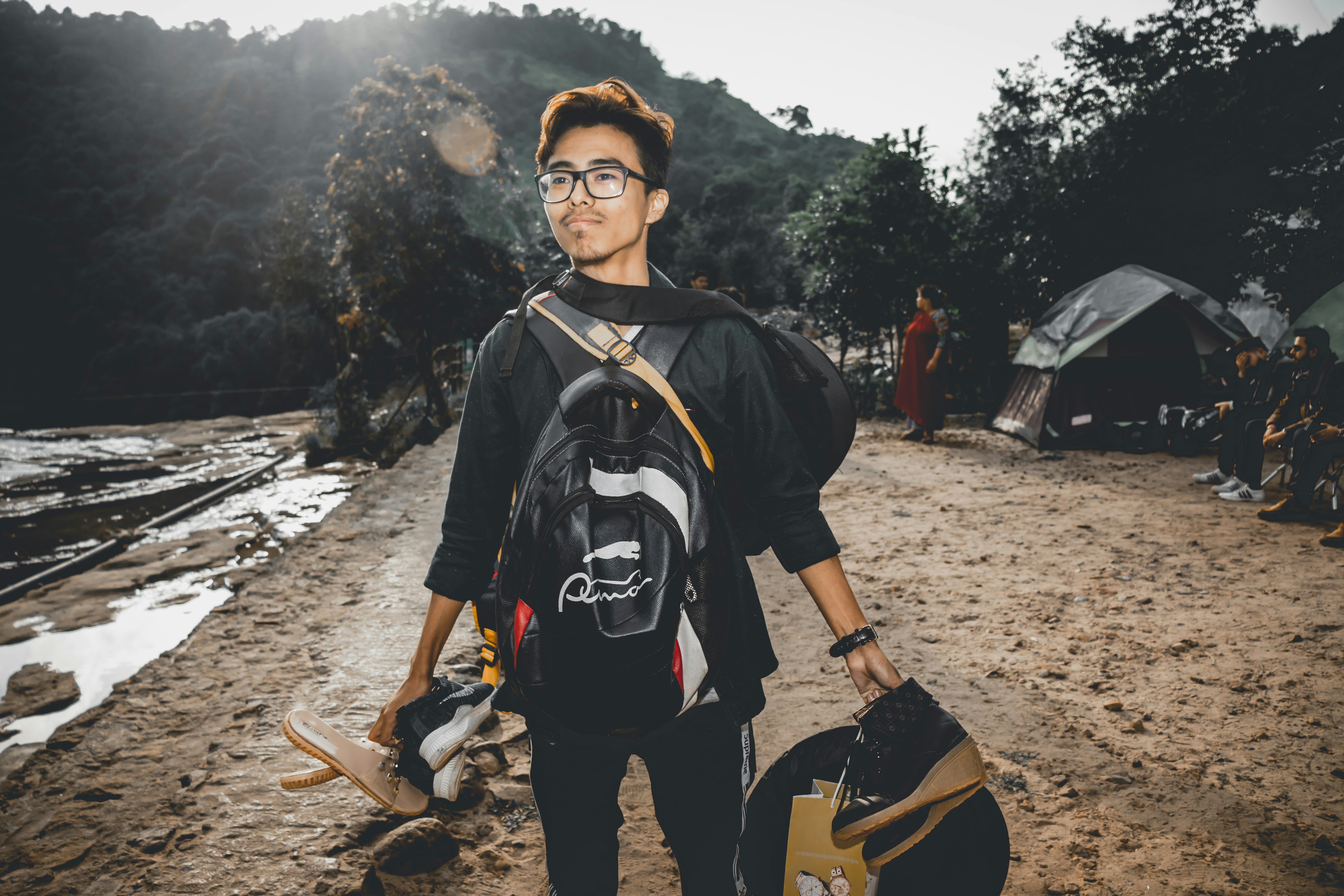man with black backpack standing on shore