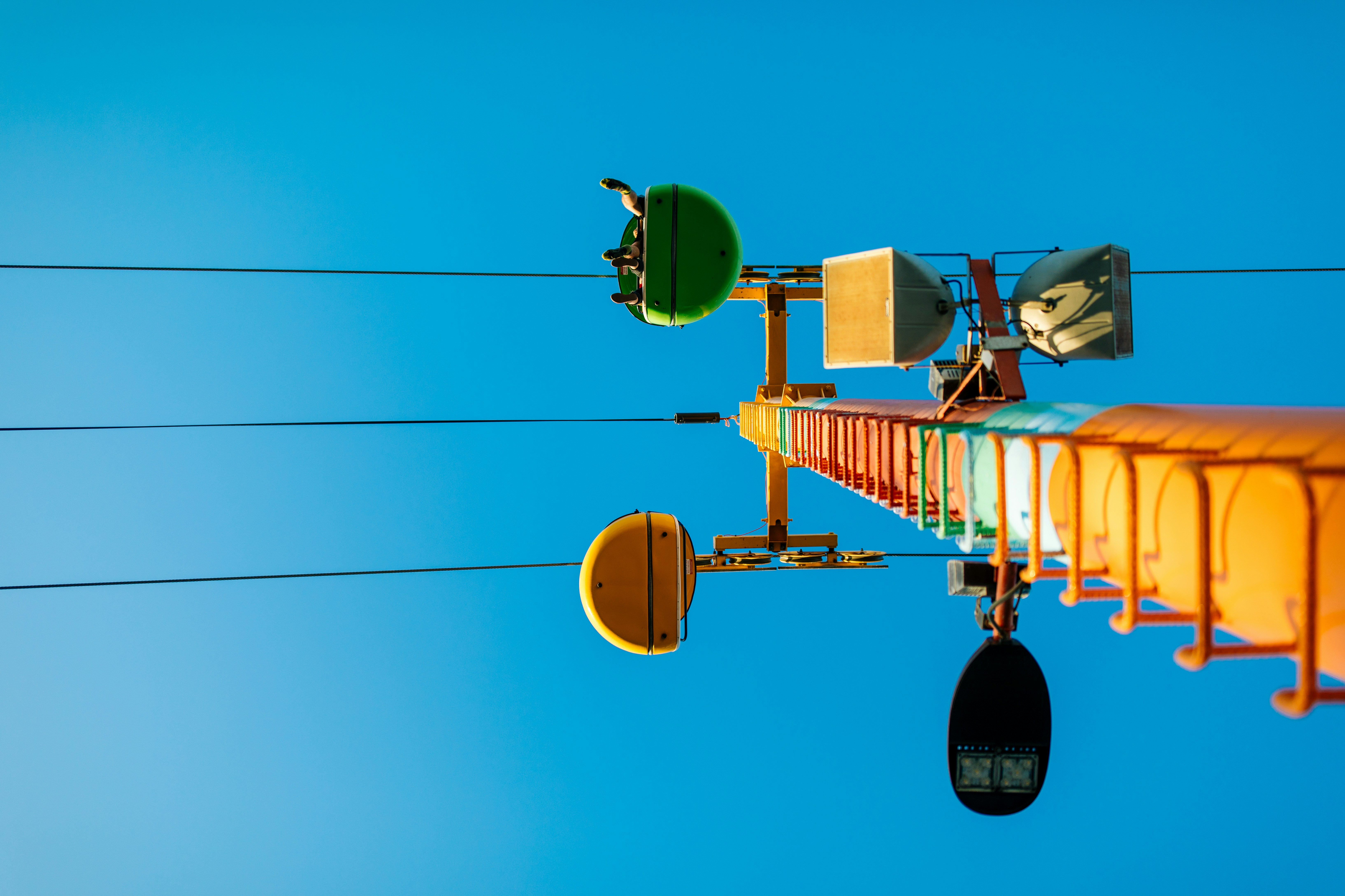 a traffic light hanging from a wire next to a blue sky