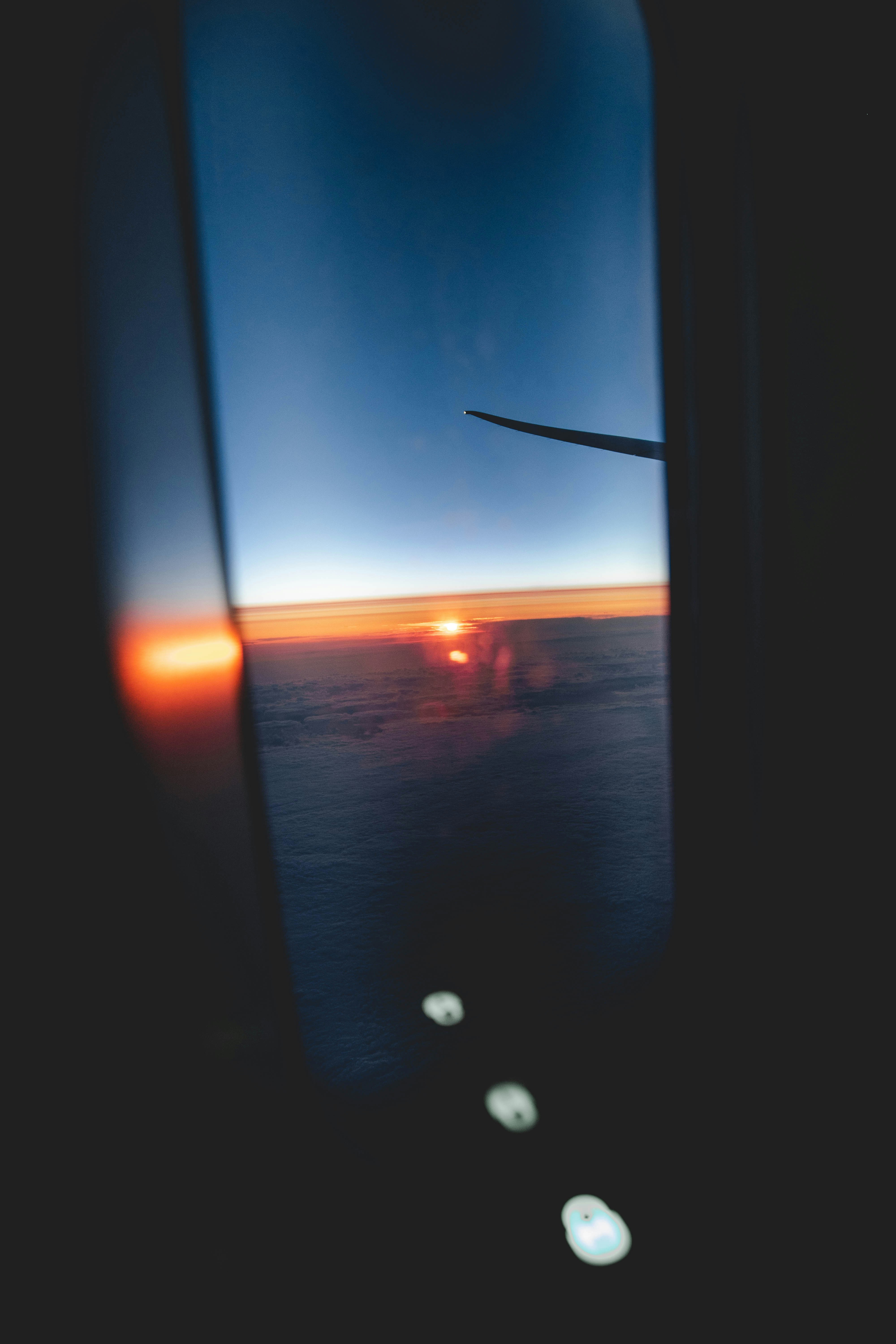 Sunset Horizon through an Airplane Window: Wing, Clouds, and Quiet Light