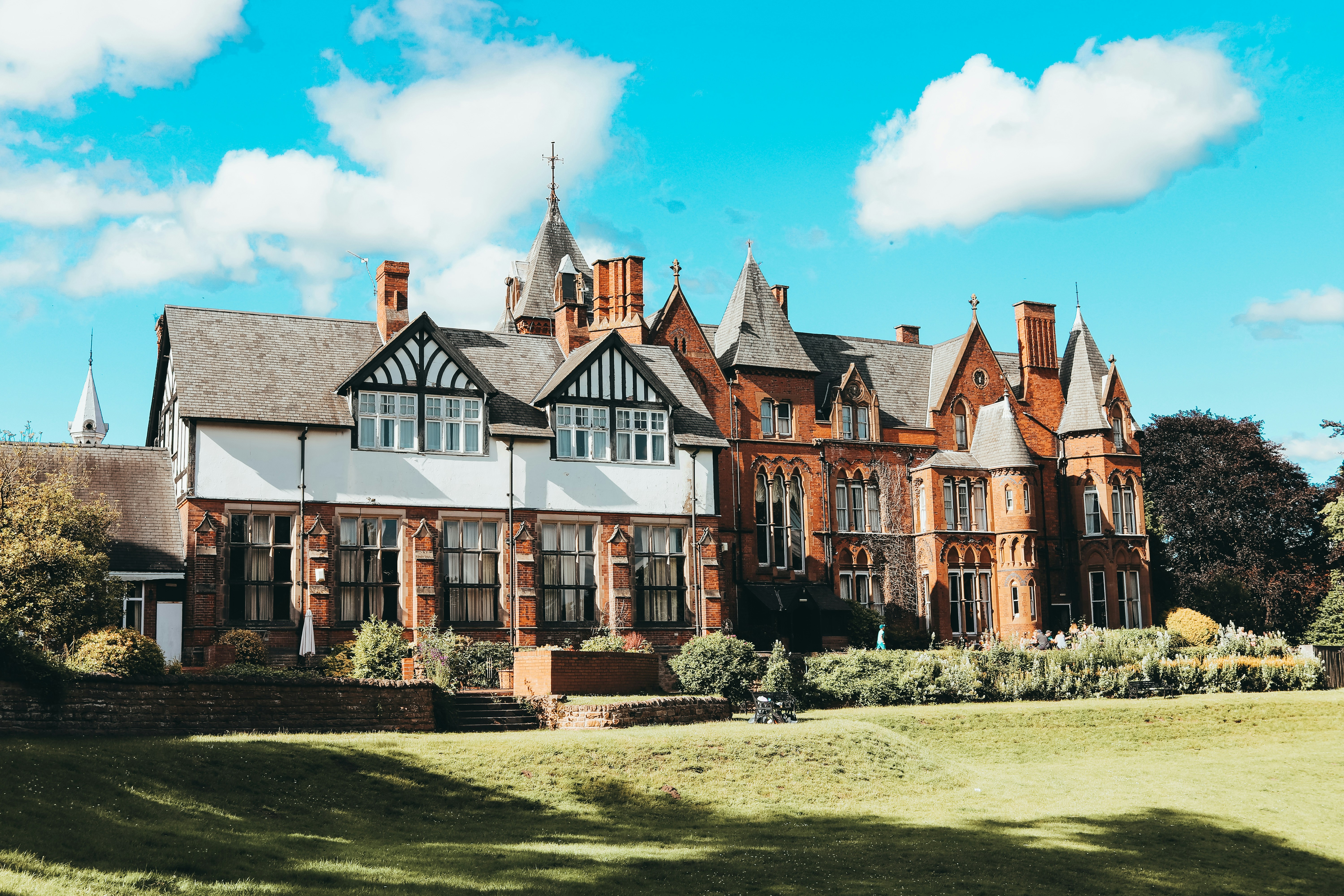 Historic lodge with intricate architecture set against a bright blue sky and lush greenery.
