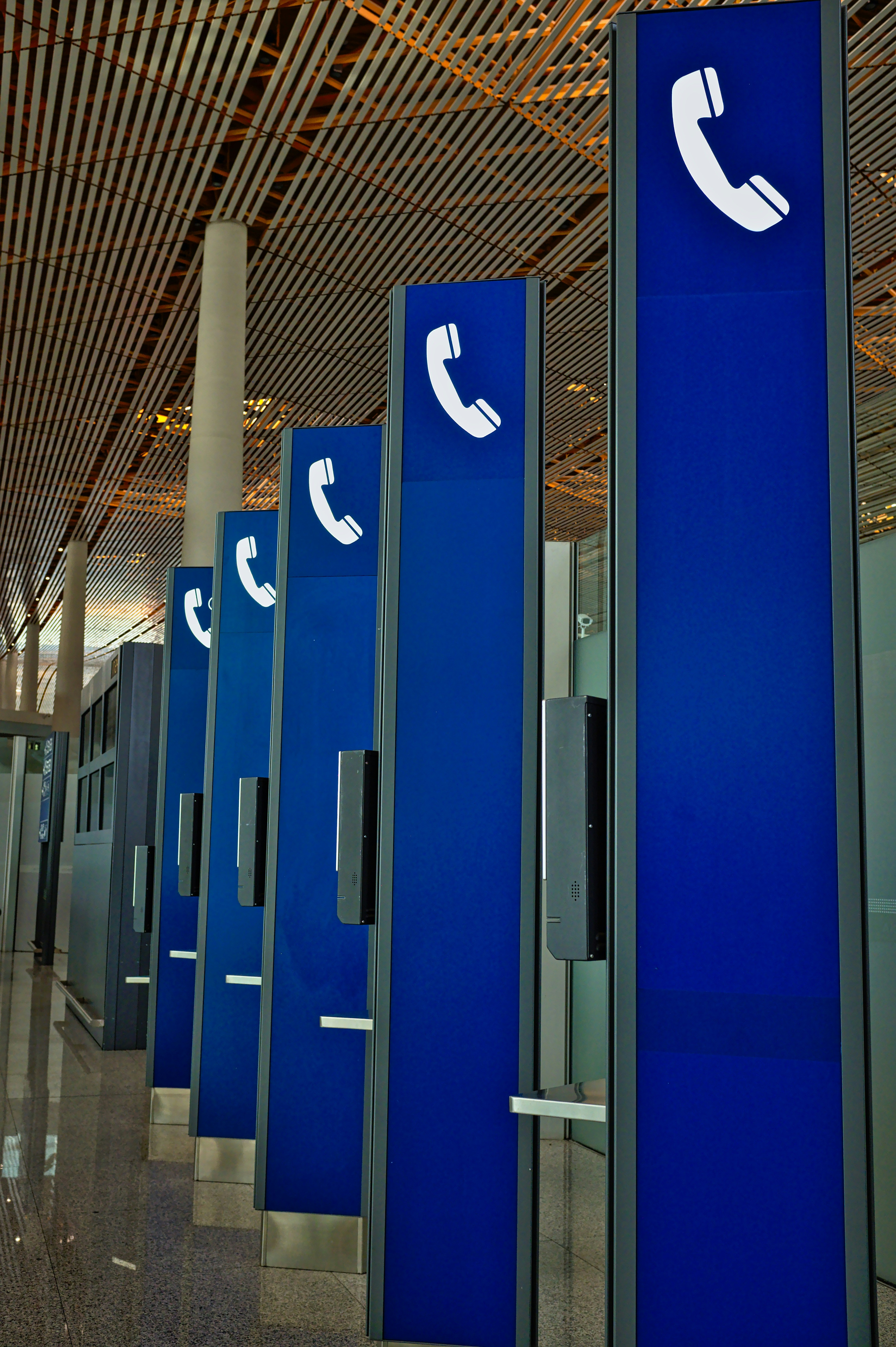 Row of blue phone booths in a contemporary setting, highlighting the intersection of technology and design.
