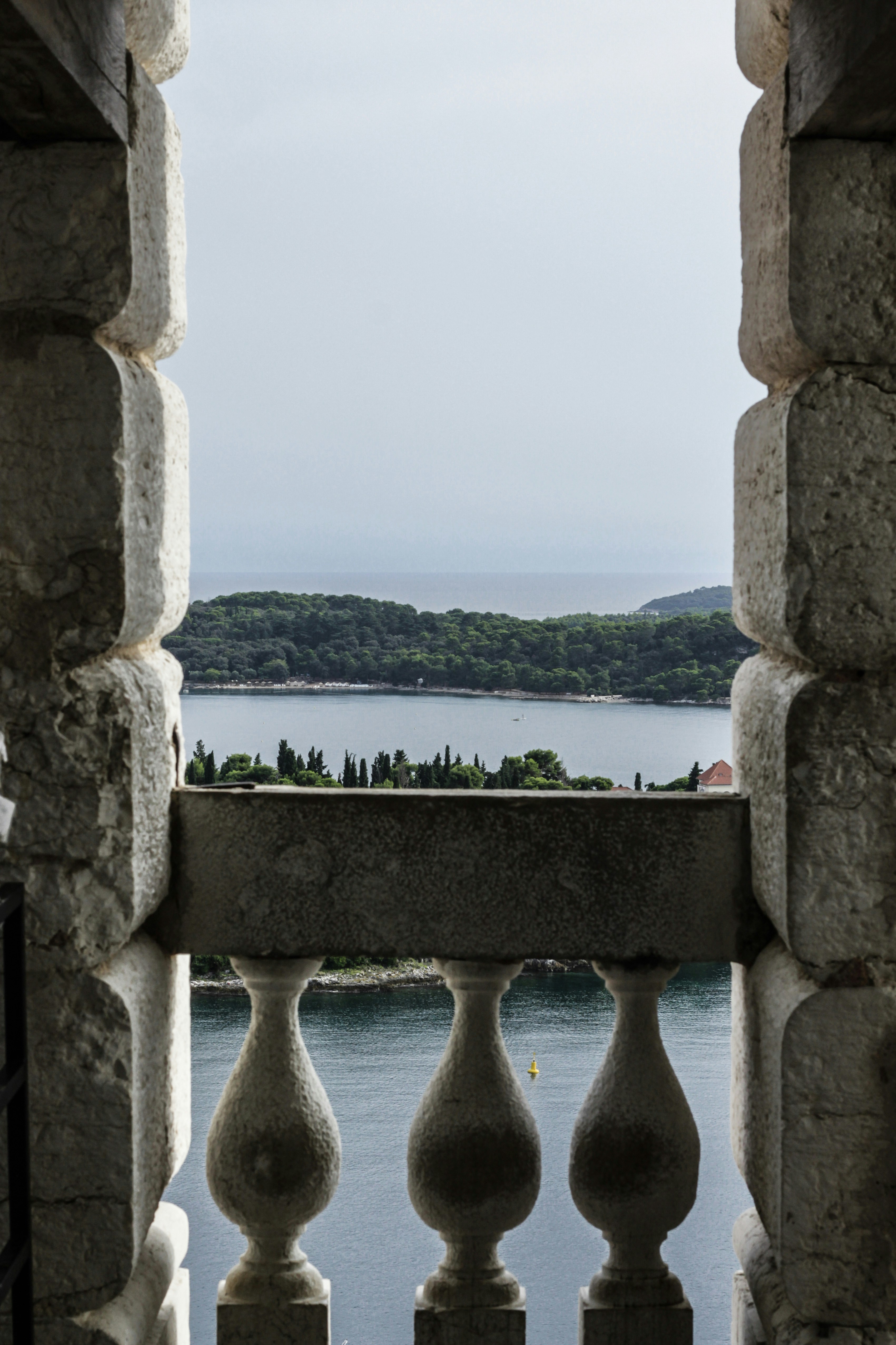 Through Stone Arches: A Seascape Framed by Time-Worn Balusters