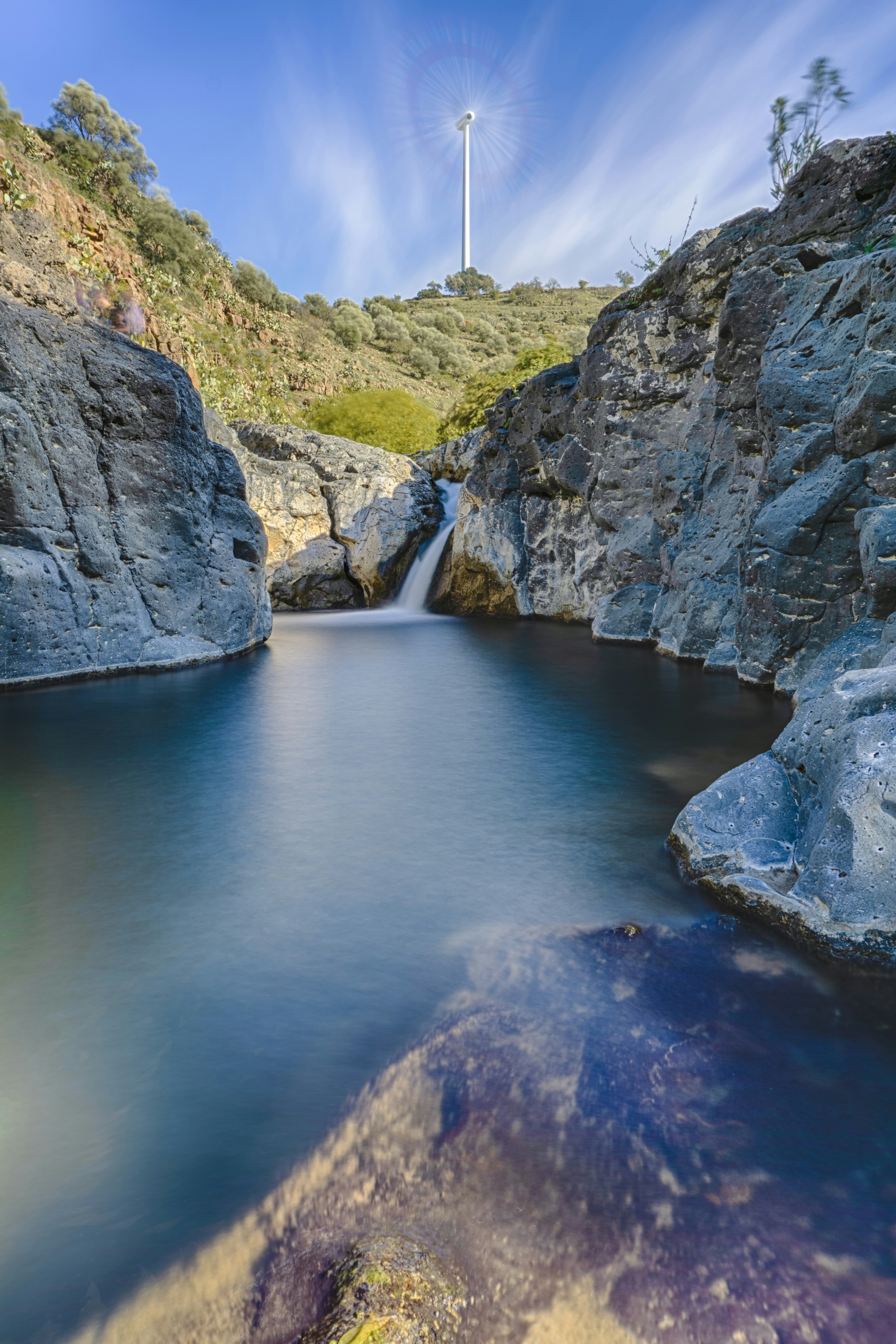 Windward Gorge: A Quiet Waterfall Framed by Granite and a Lone Turbine