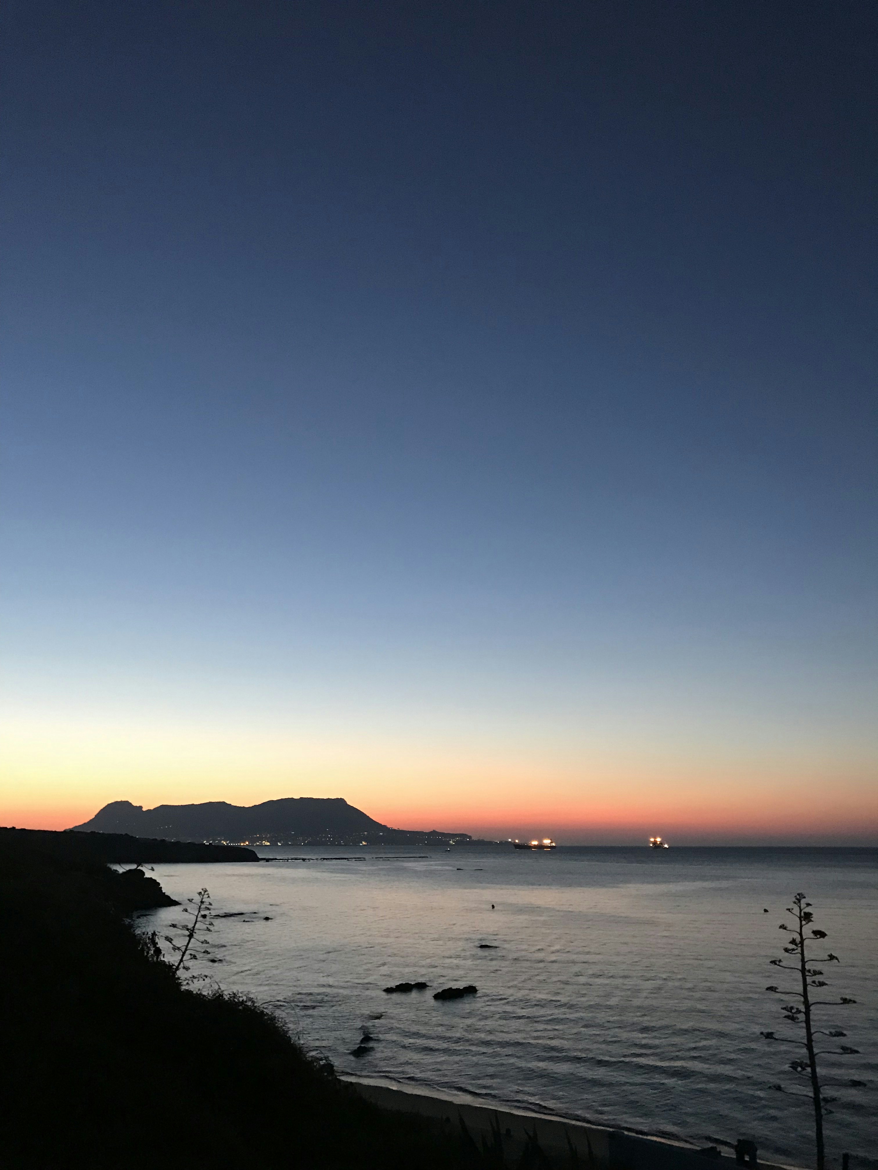 Horizon Ember: Silhouetted Coastal Ridge at Sunset