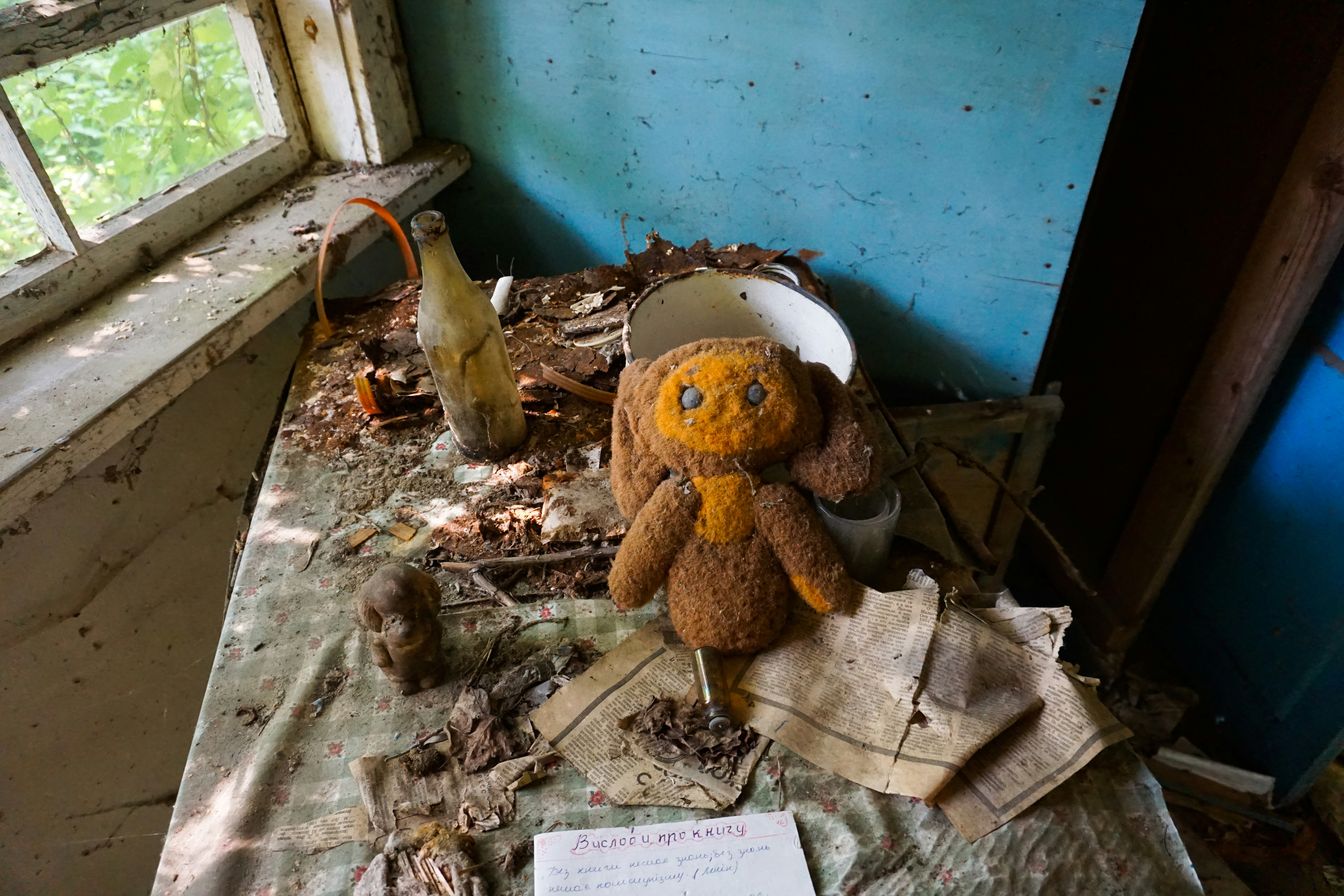 Dusty Corner Shrine: A Plush Monkey Among Debris in a Forgotten Room