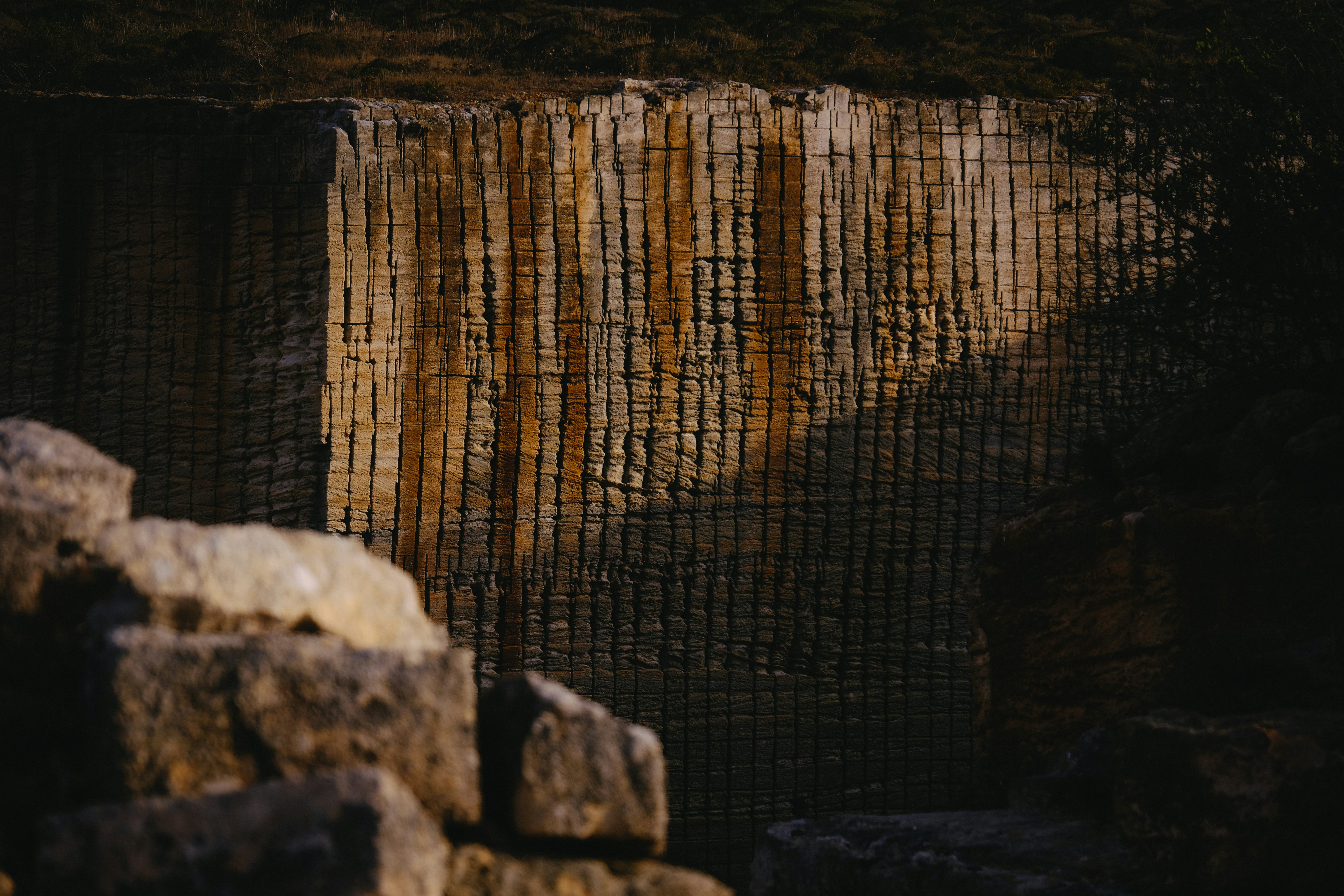 Amber-lit Basalt Columns Rise from Twilight Shadow