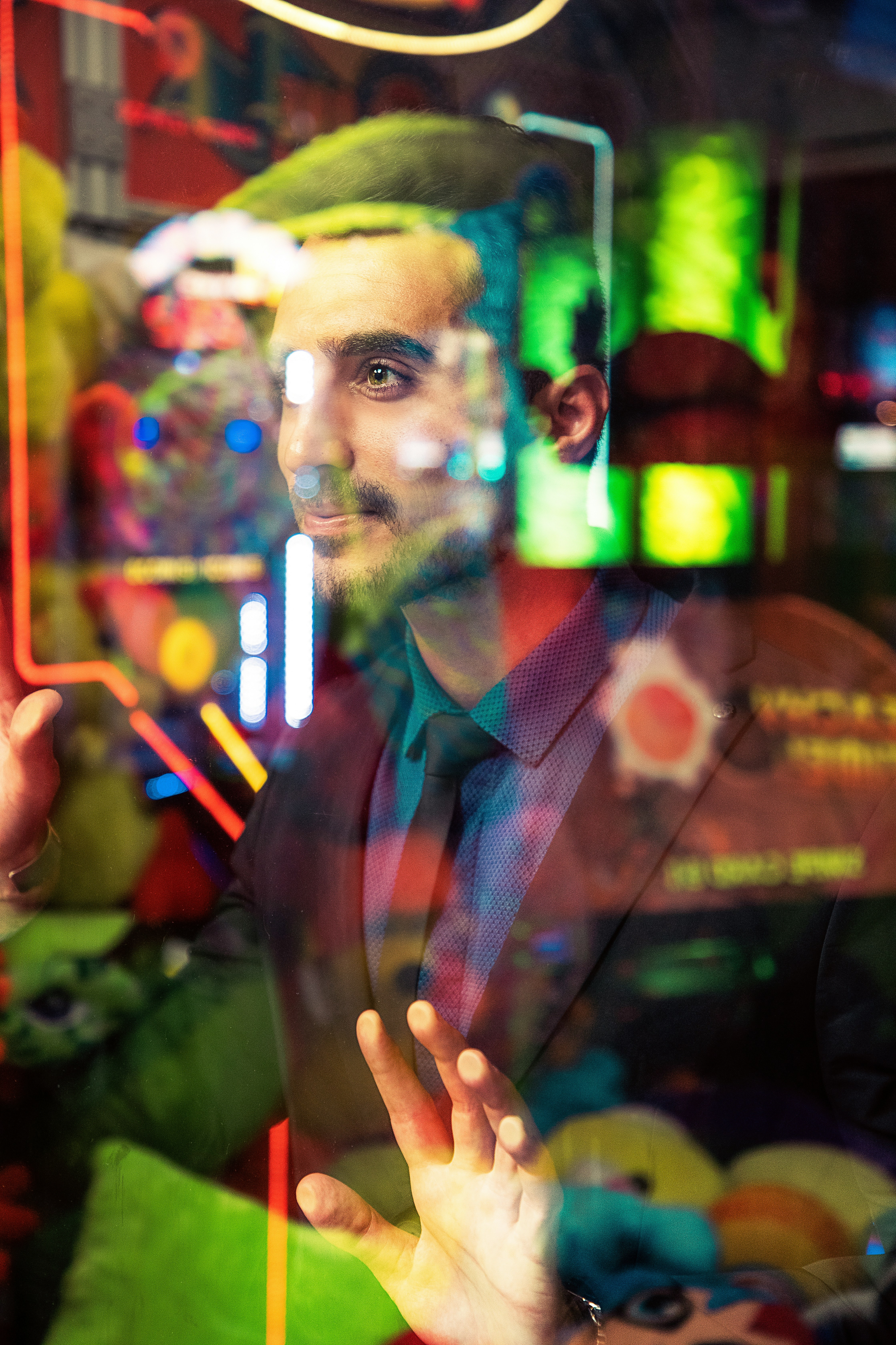 Neon Reflections: A Portrait Framed by Urban Glass and Color