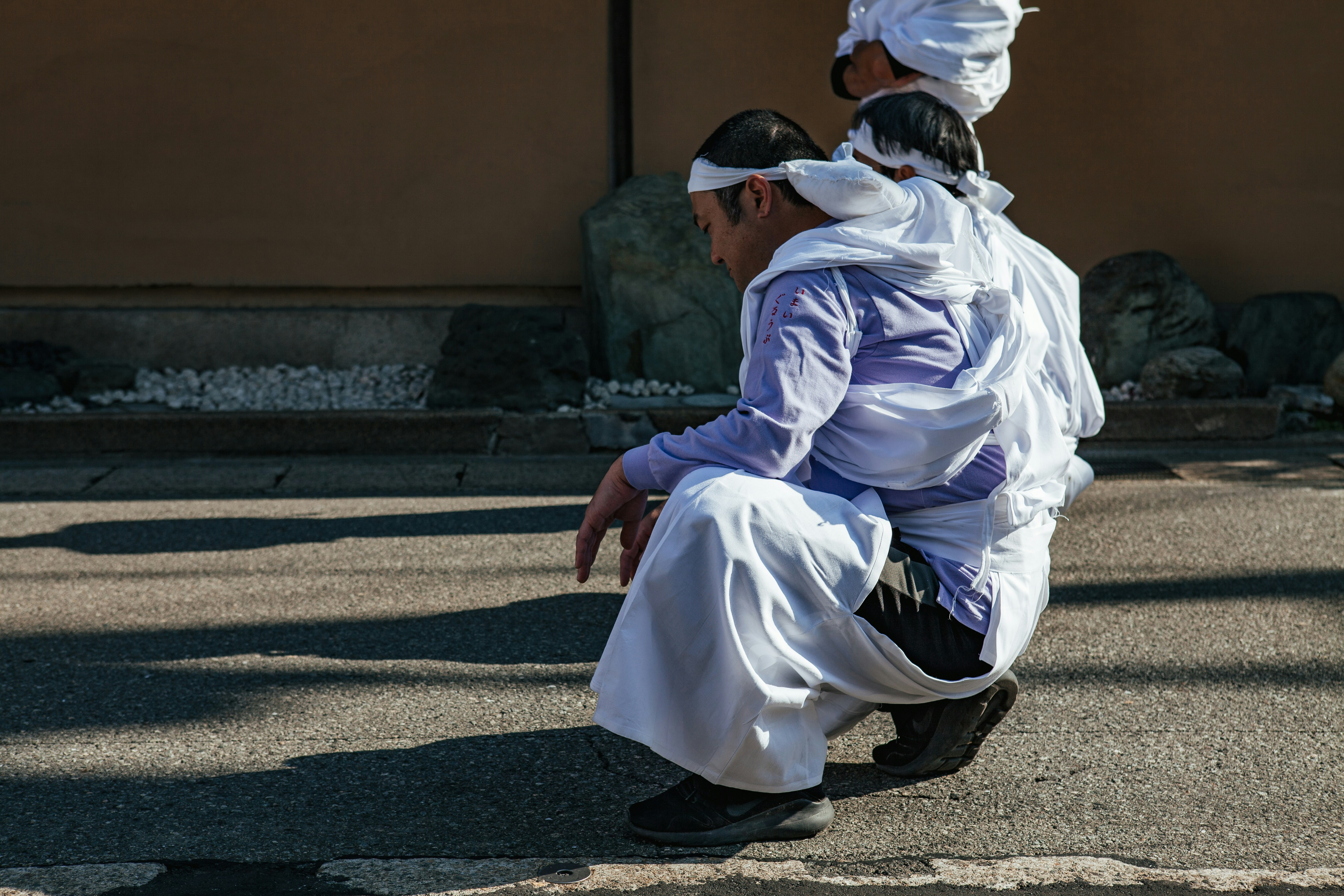 Shadowed Ritual: A Quiet Moment Between Two Attendants