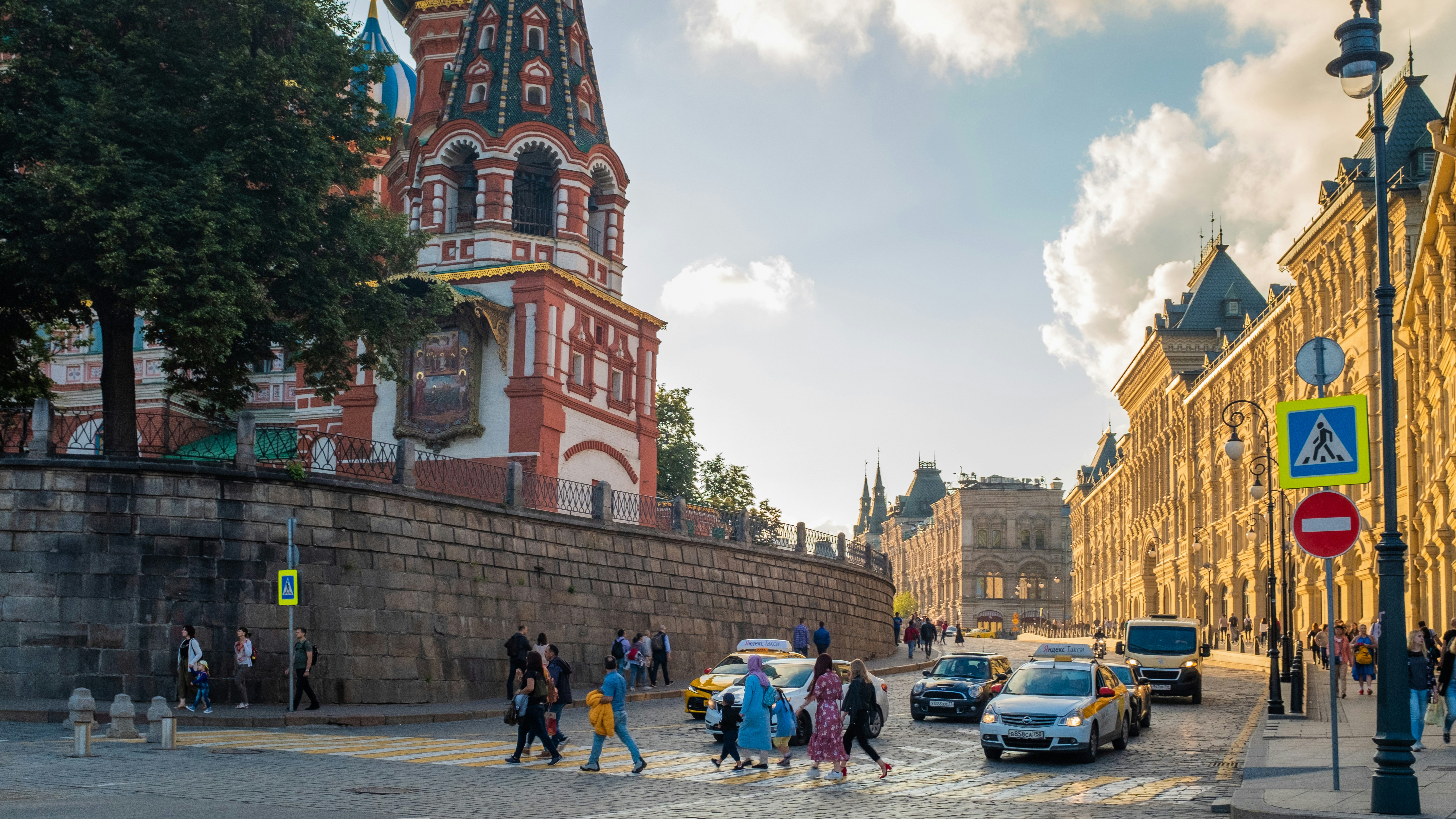 Sunlit Kremlin Street: Cars, Pedestrians, and Historic Architecture