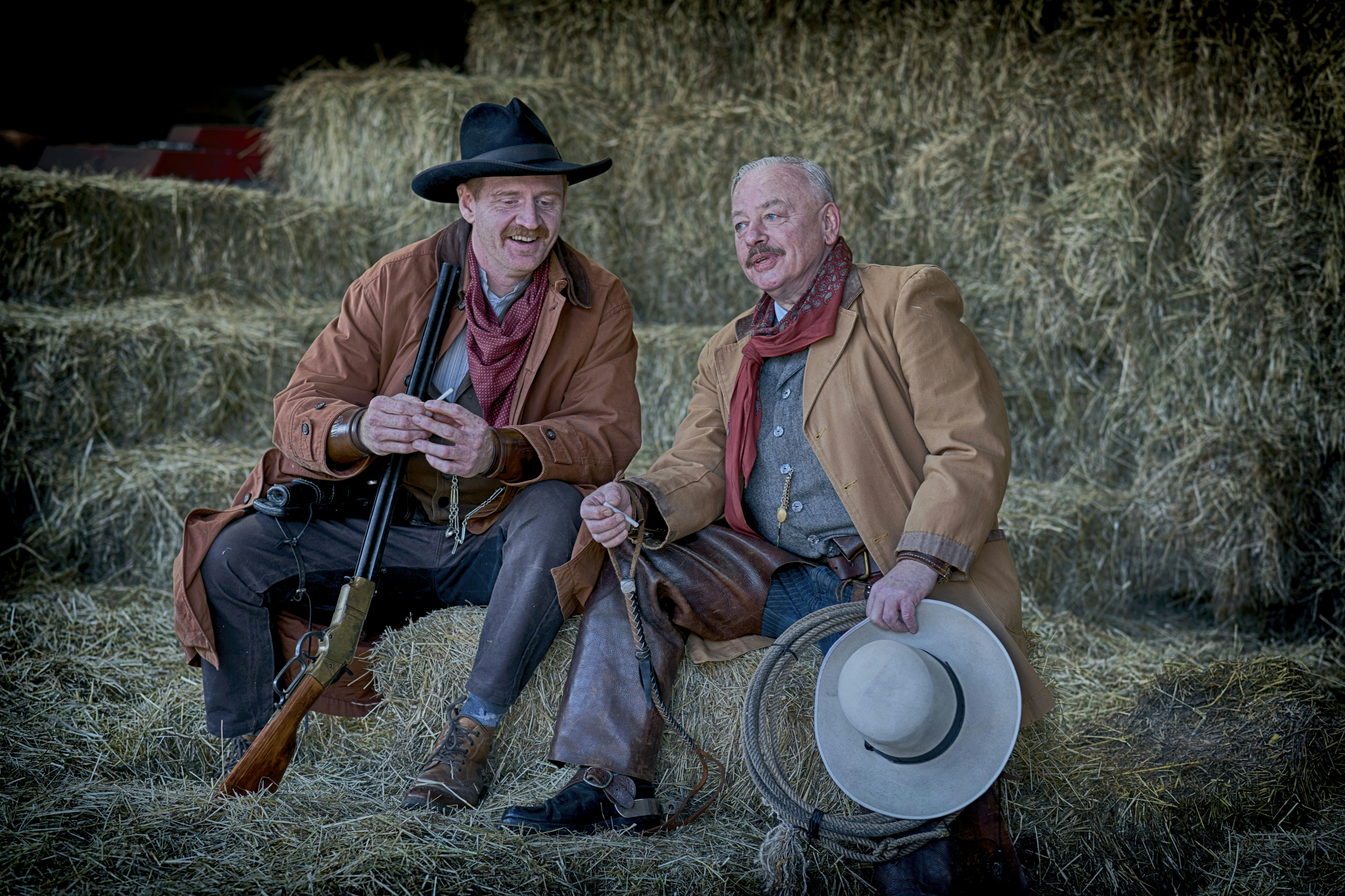 Two men in brown coat sitting on hay stack photo – Free Human Image on ...