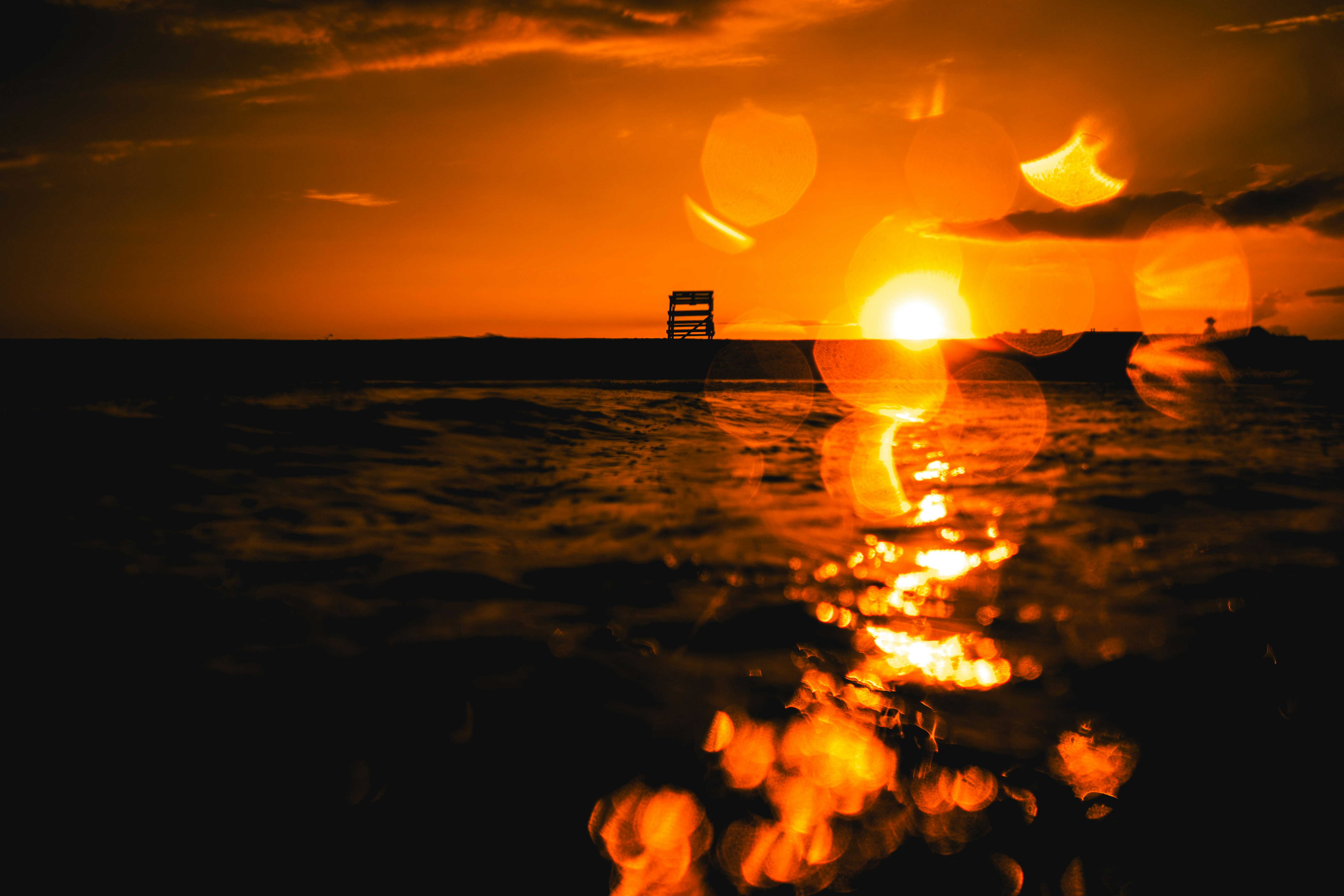 Sunlit Orbs Across a Quiet Sea: Sunset Through Lens Flares