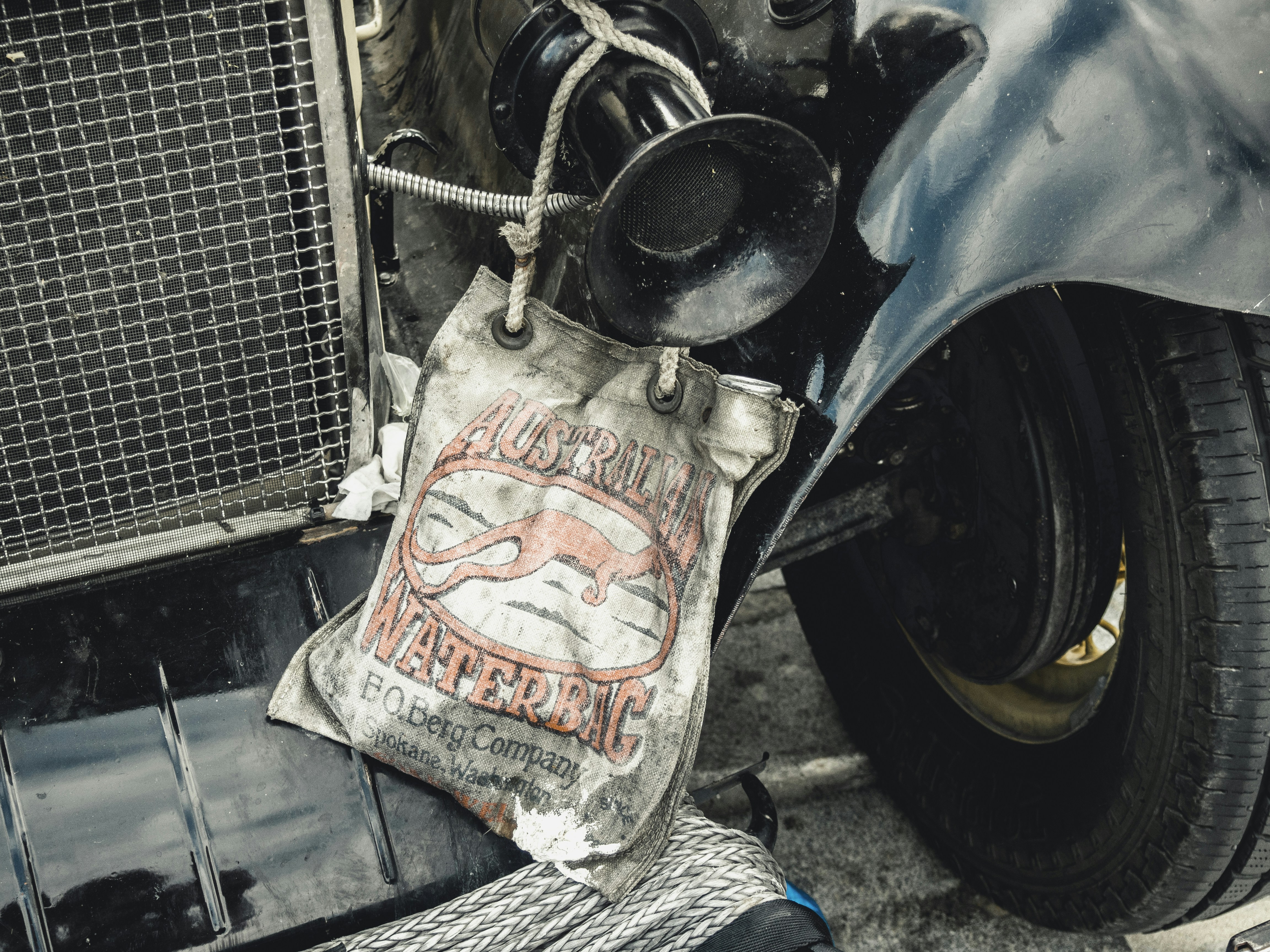 Dangling Australian Waterbag tag on a vintage car grille