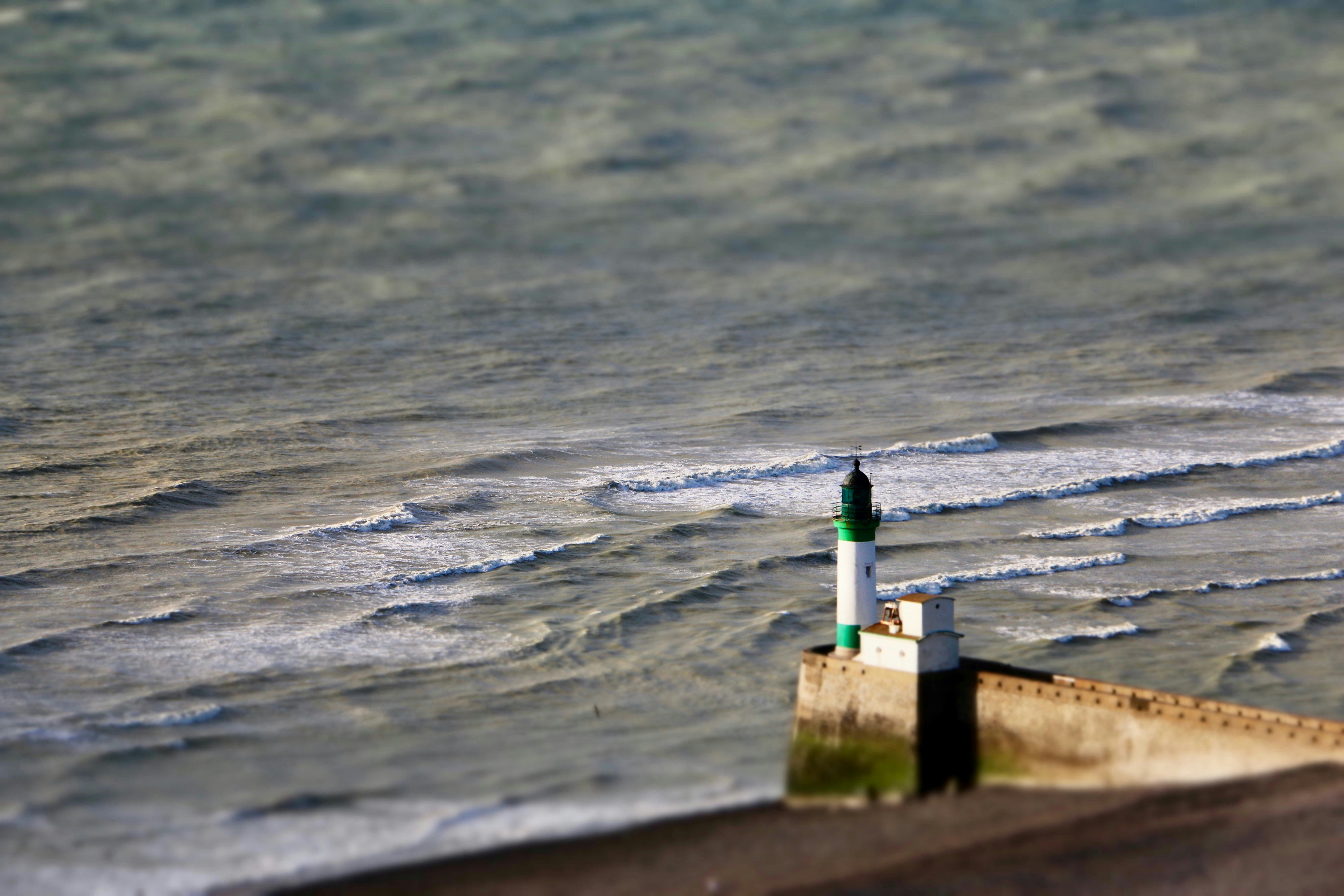 Beacon at the Edge: Lighthouse on a Weathered Breakwater