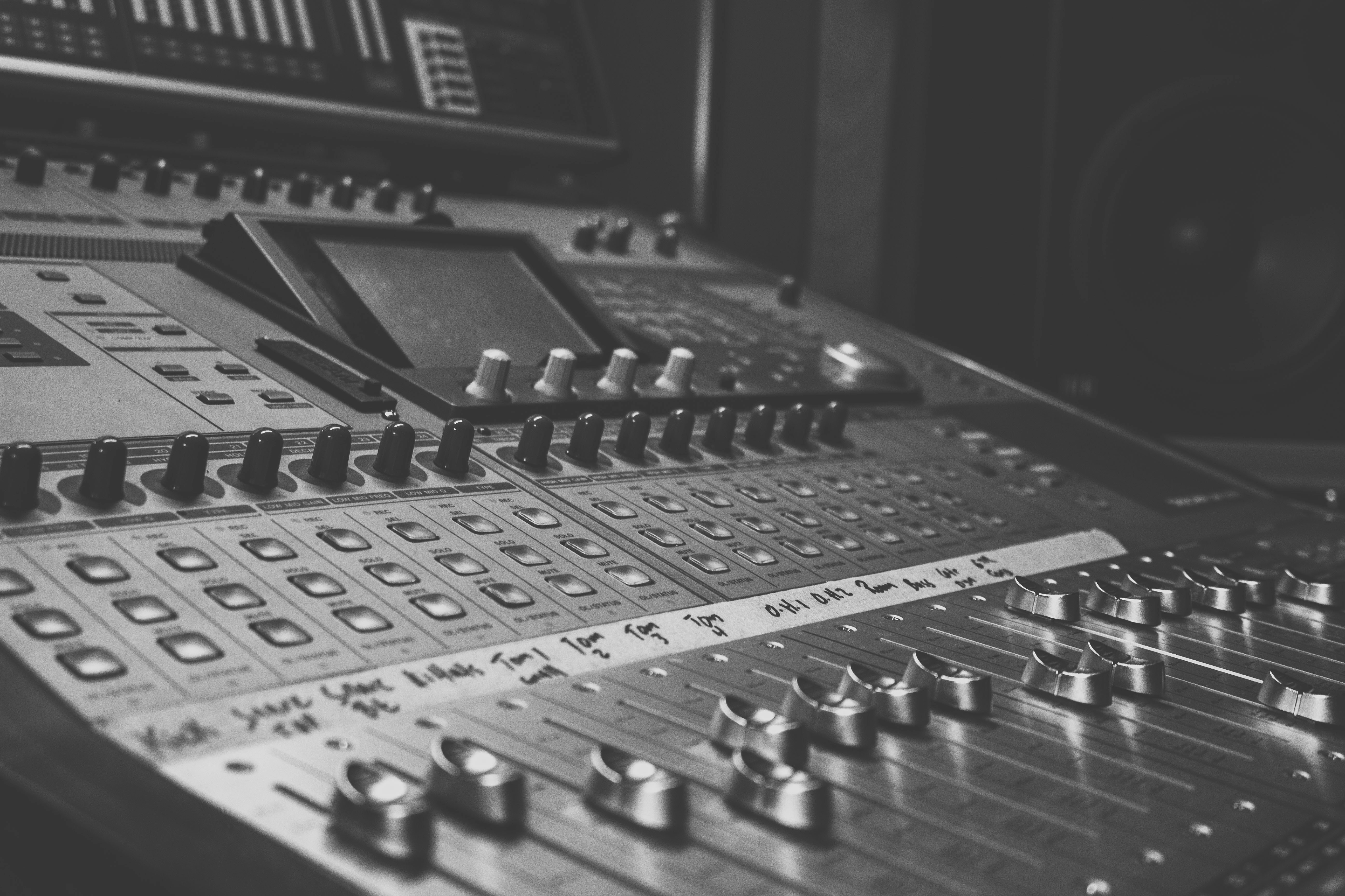 Close-up of a professional audio mixing console with various knobs and sliders, showcasing the intricate details of sound engineering equipment.