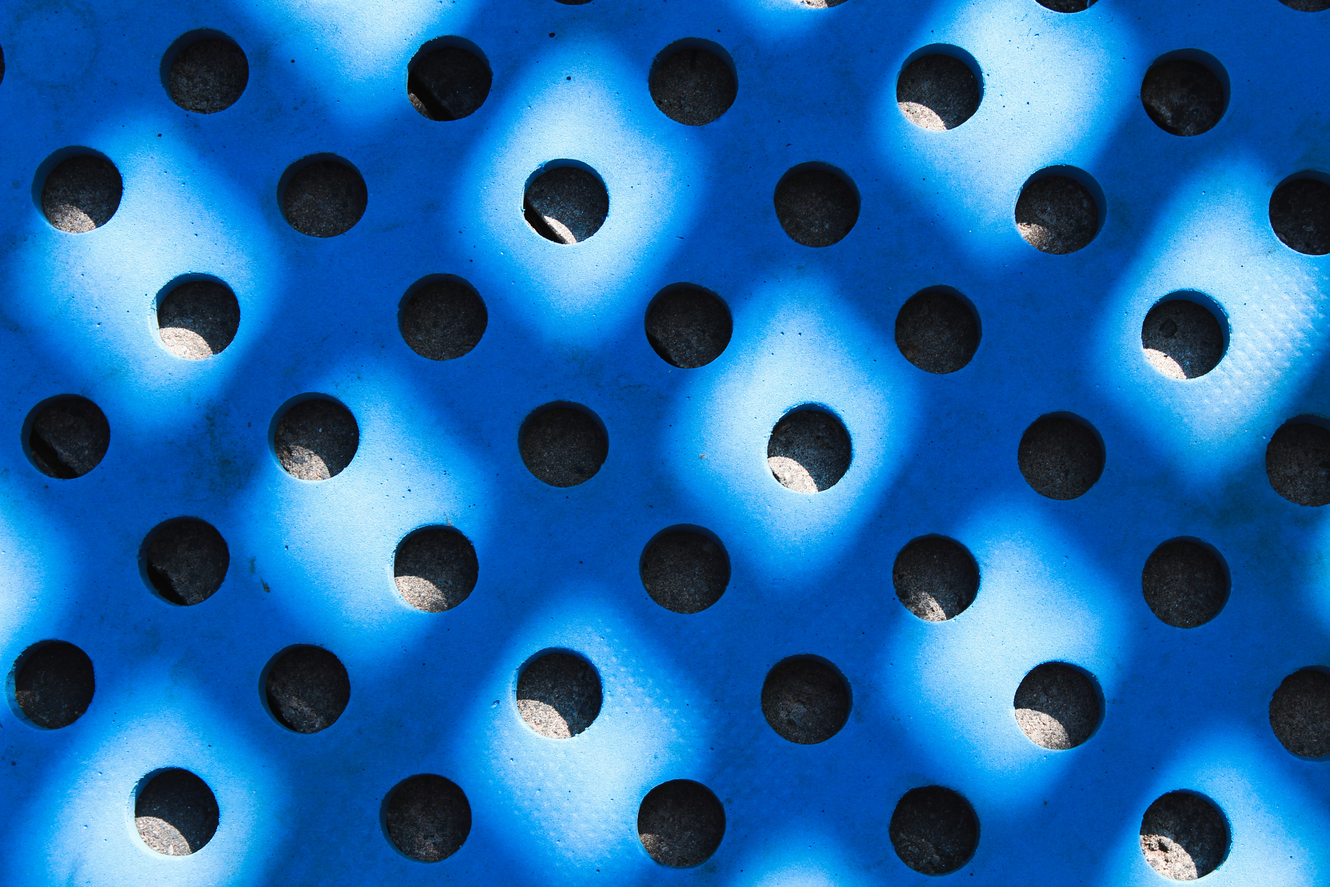 A blue perfored surface with holes in it photo – Free Blue Image on ...