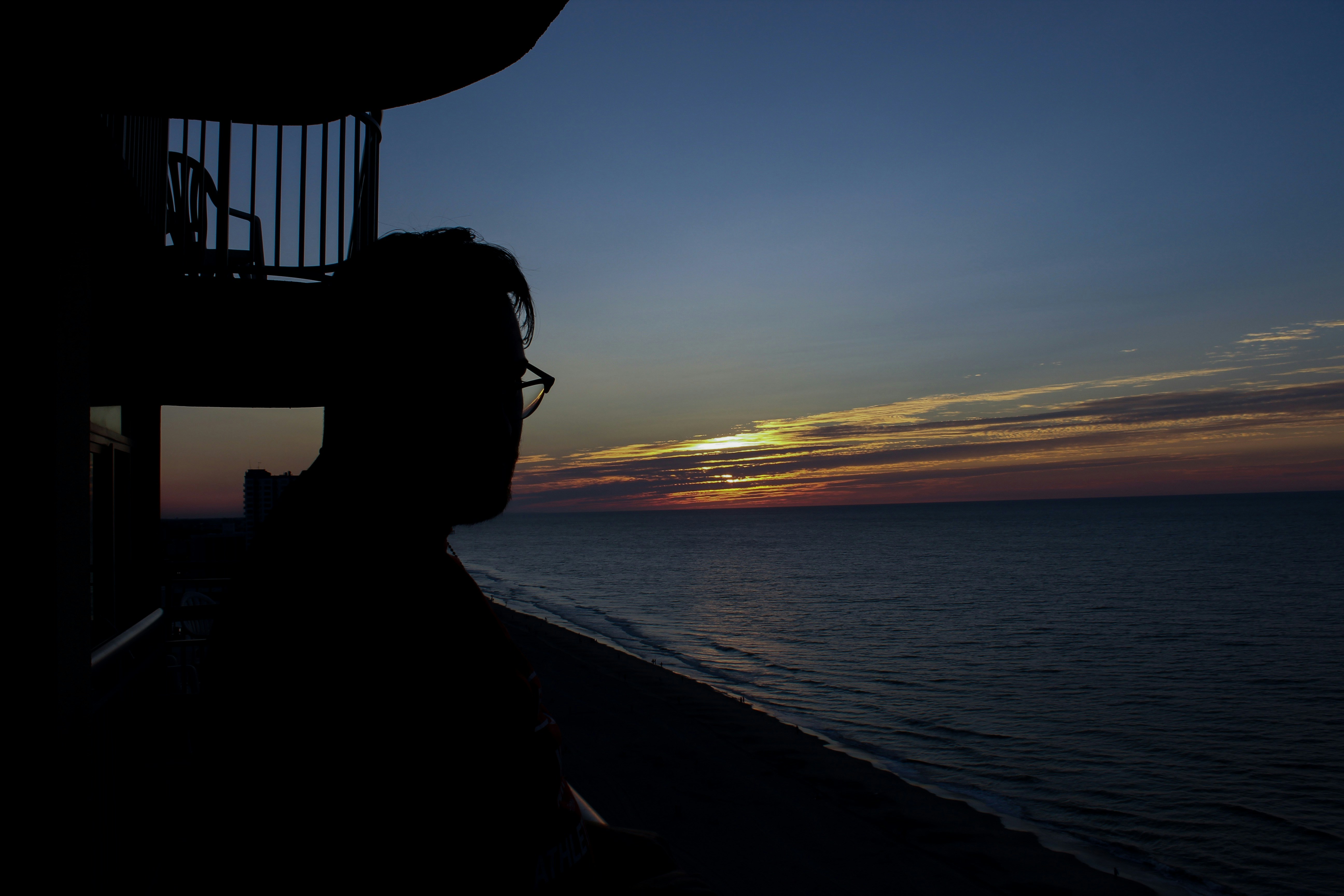 Silhouette at Sunset: A Quiet Moment on the Waterfront