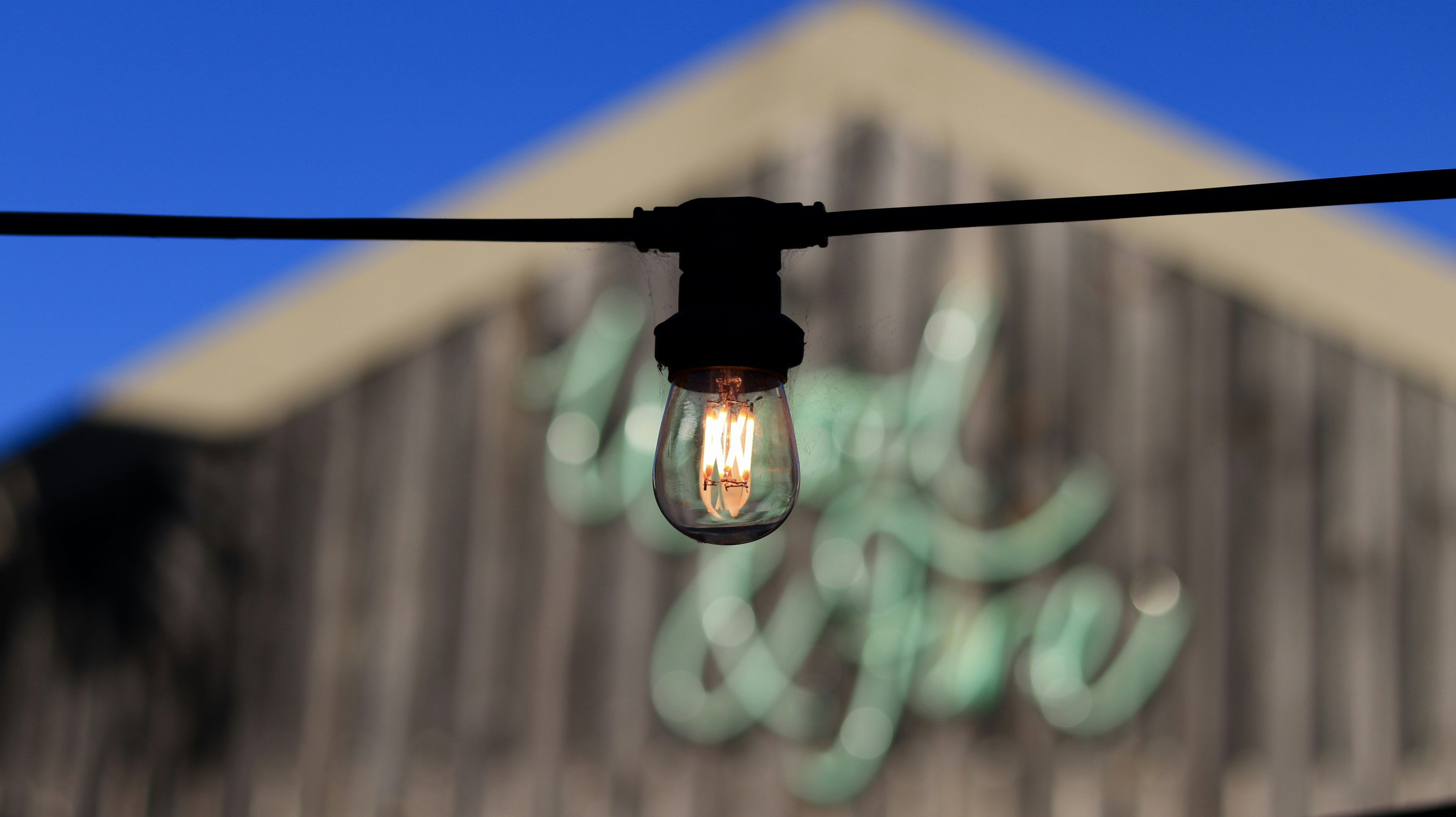 Edison Bulb Framing a Neon Café Glow