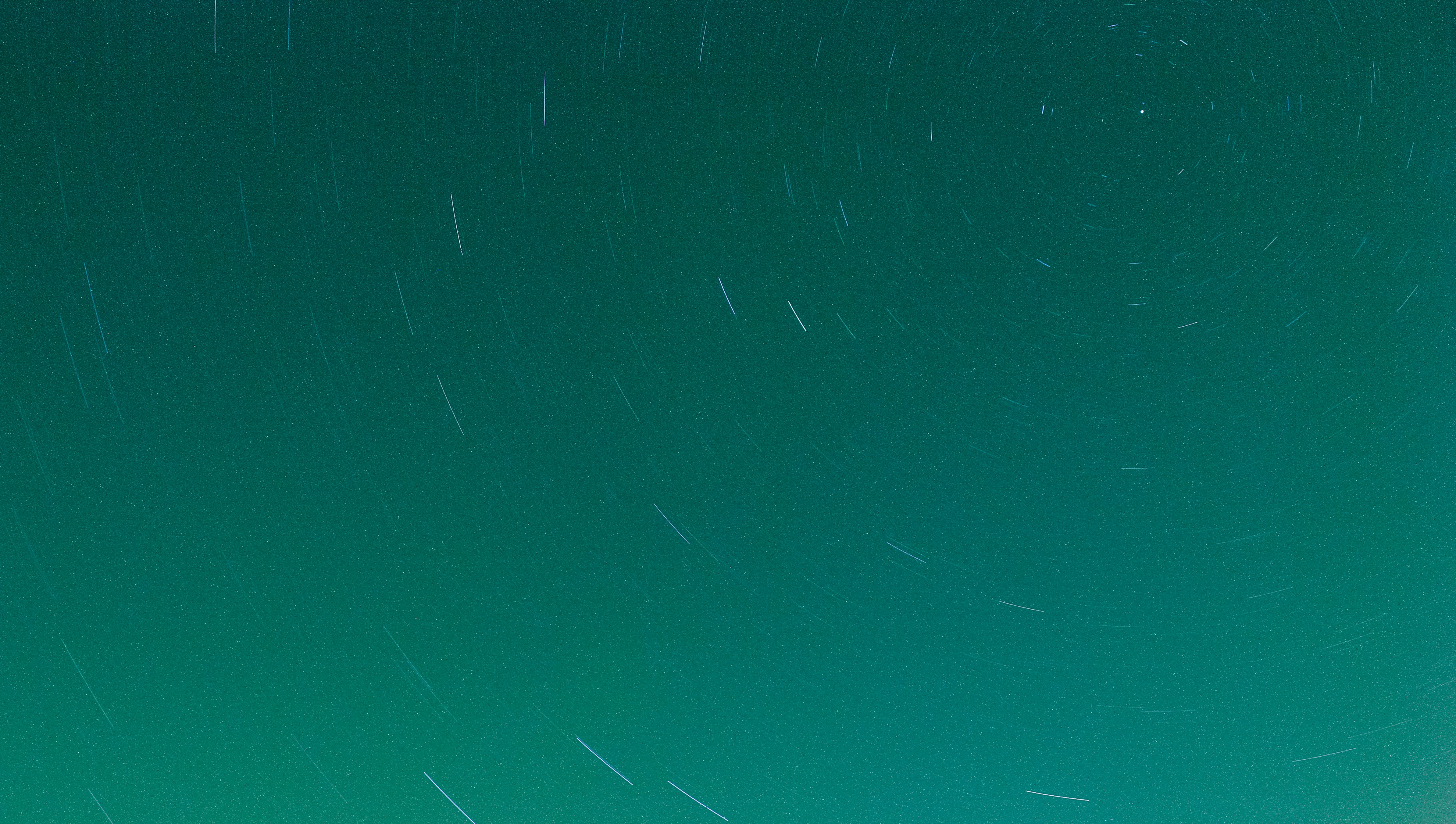 a group of people standing on top of a hill under a star filled sky