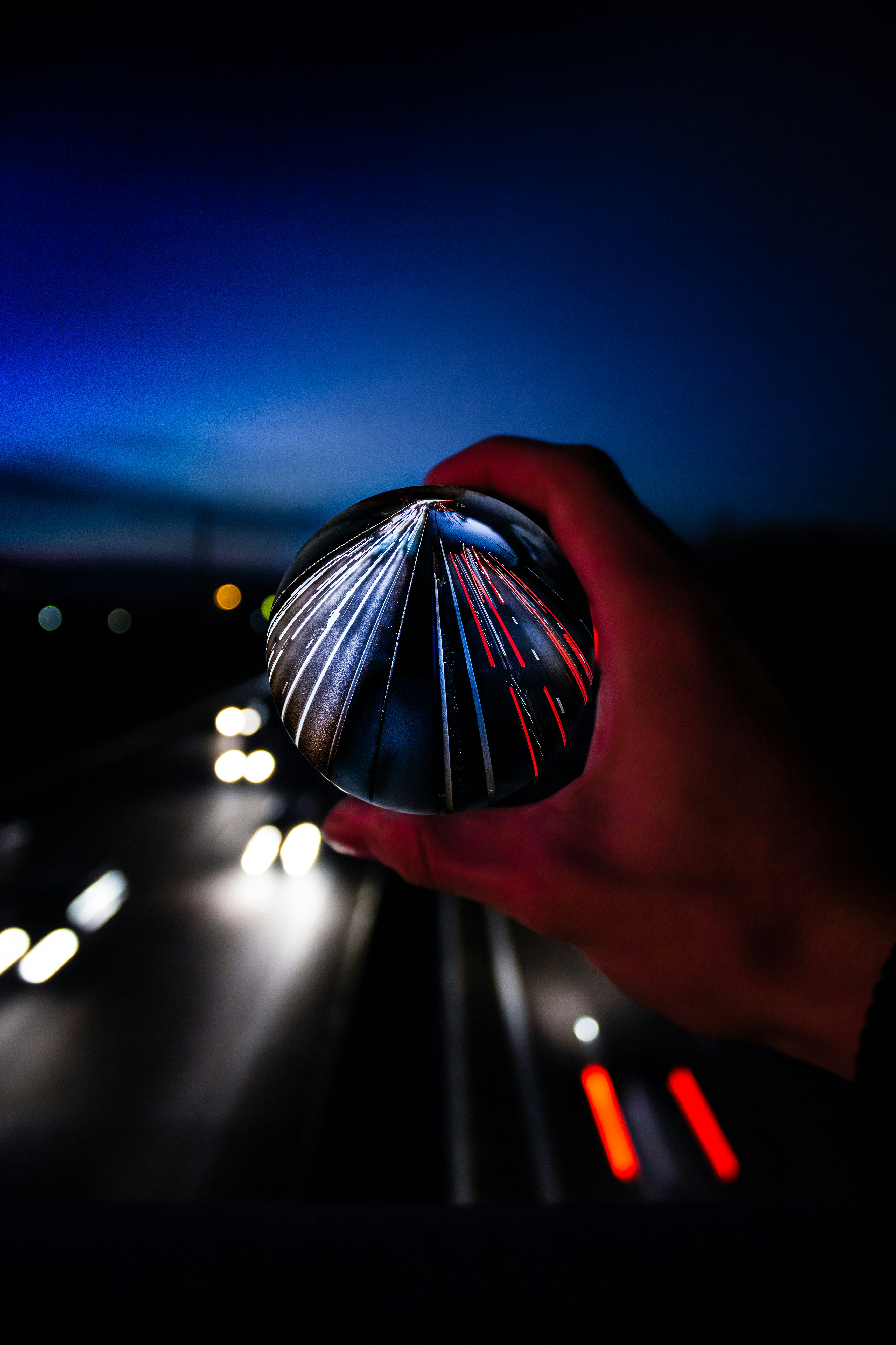Lens of Lights: A Glass Ball Framing a Night Highway