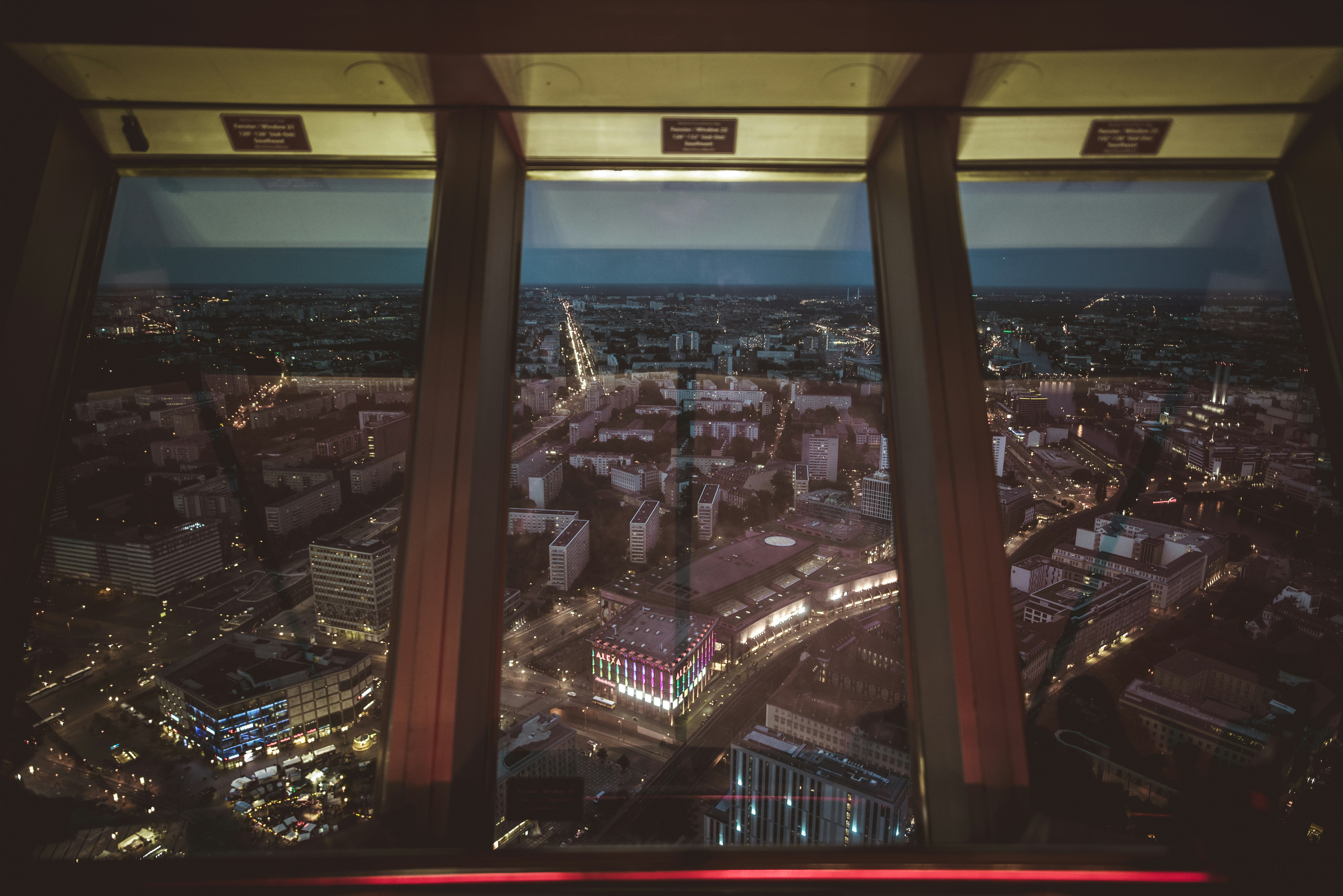 Three-Pane Nightscape: City Lights Framed by a Towering Window