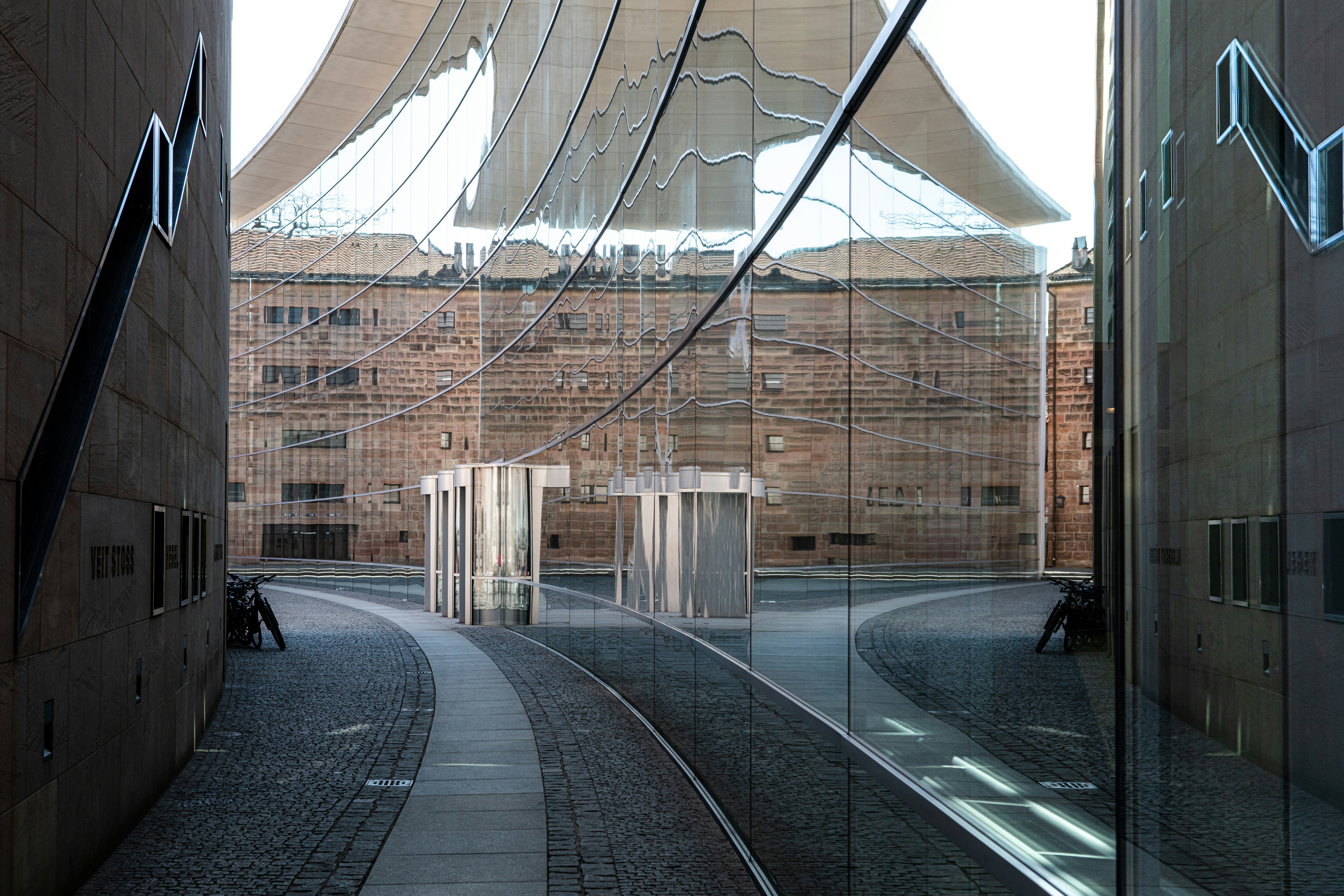 Reflection of narrow pathway on mirror walled building photo – Free ...