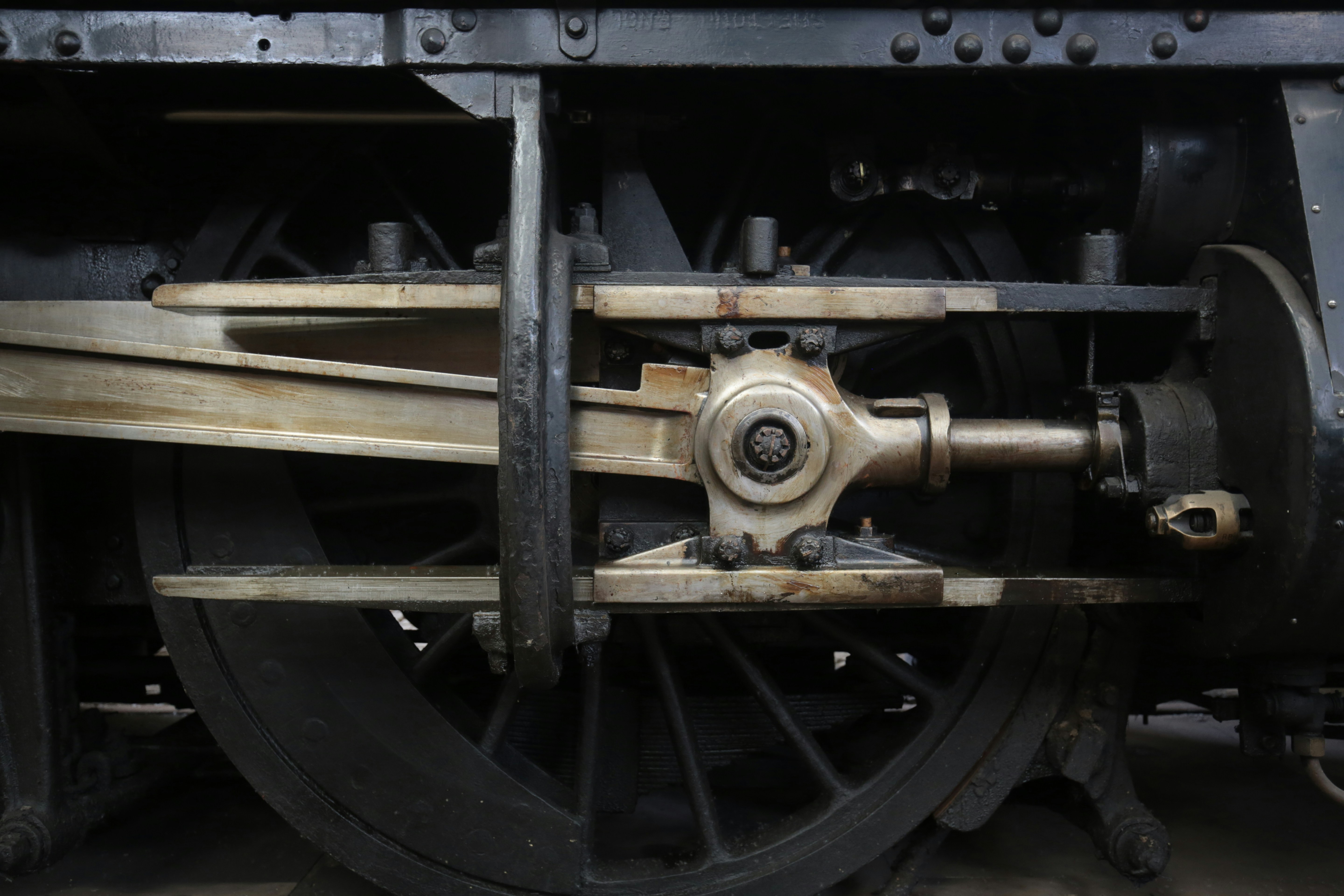Close-up of connecting rods and wheels on a historic steam engine.