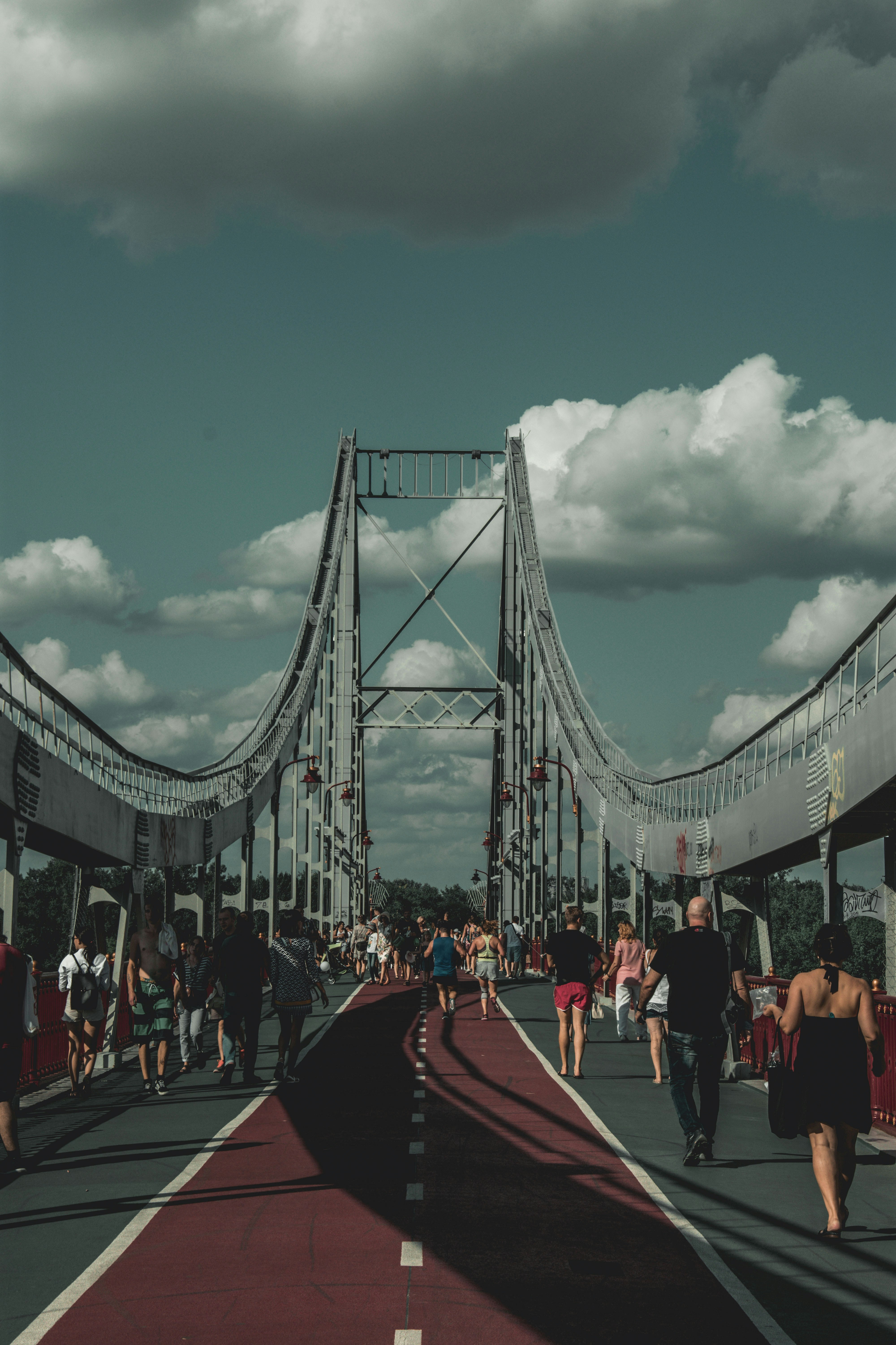 A group of people walking across a bridge photo – Free Grey Image on ...