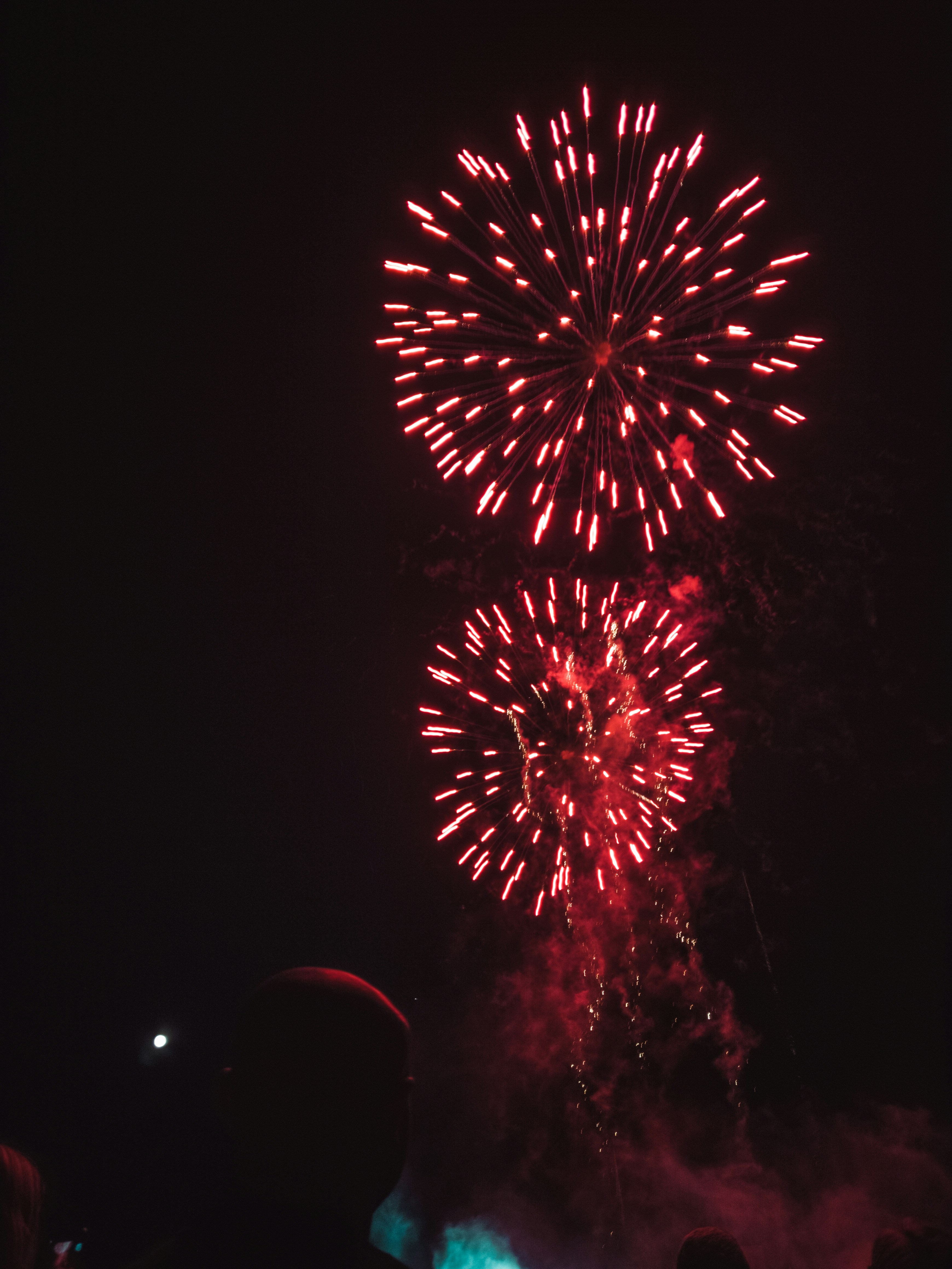 Crimson Firework Blossoms Over a Night Crowd