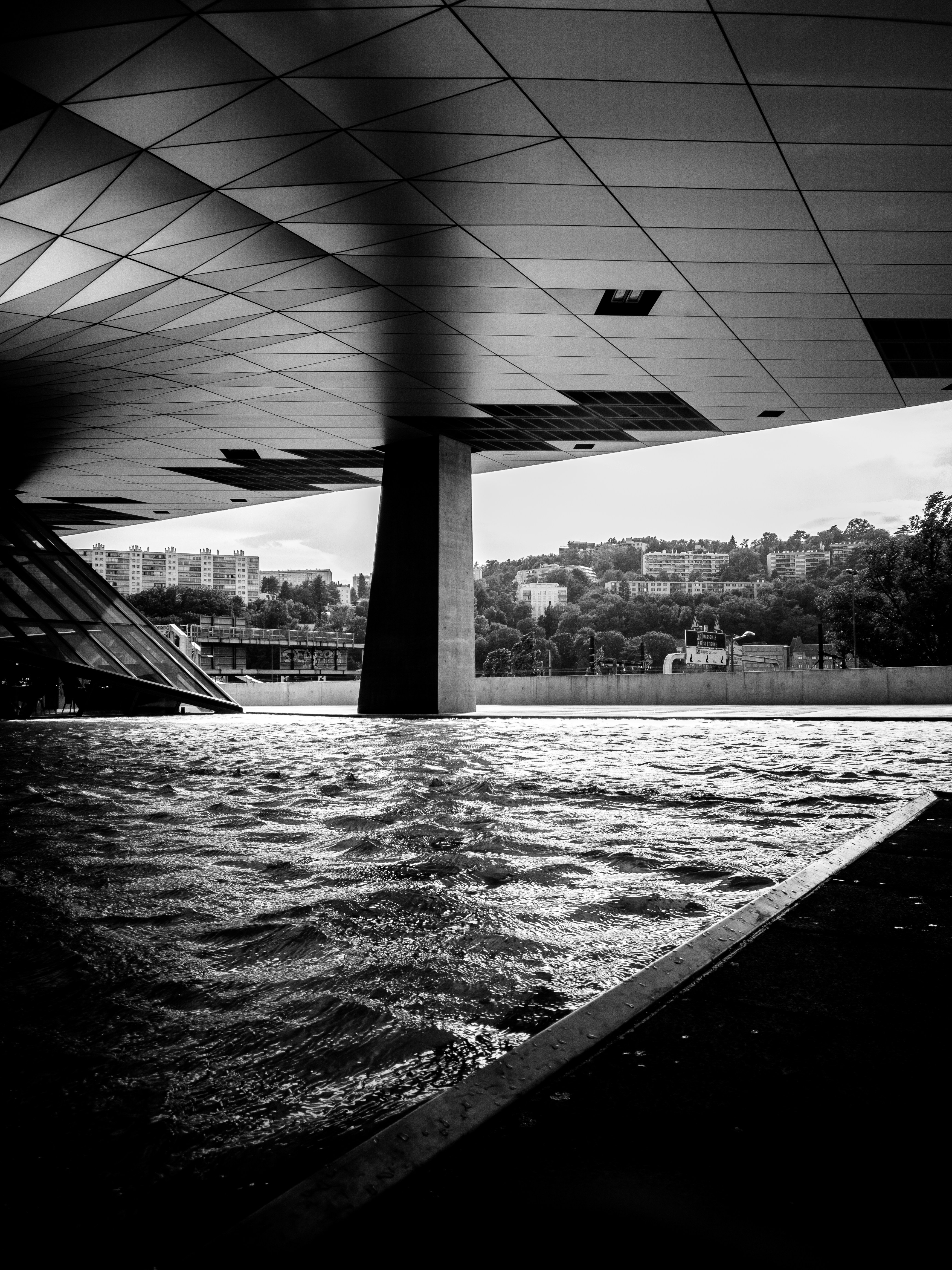 Monolithic Pillar Framing the River under a Geometric Canopy