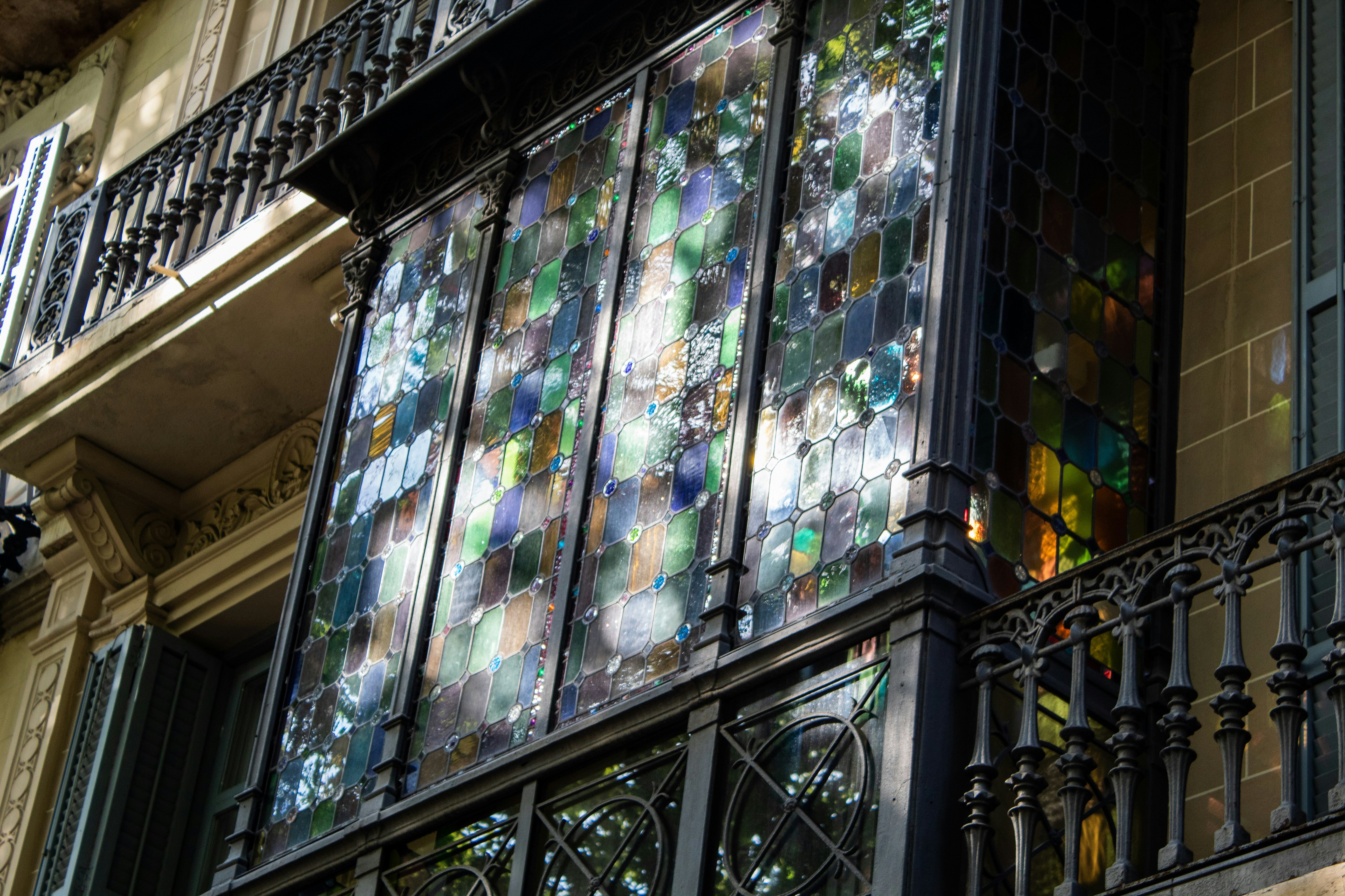Color-Charged Glass Mosaic Framed by Vintage Ironwork on a City Facade