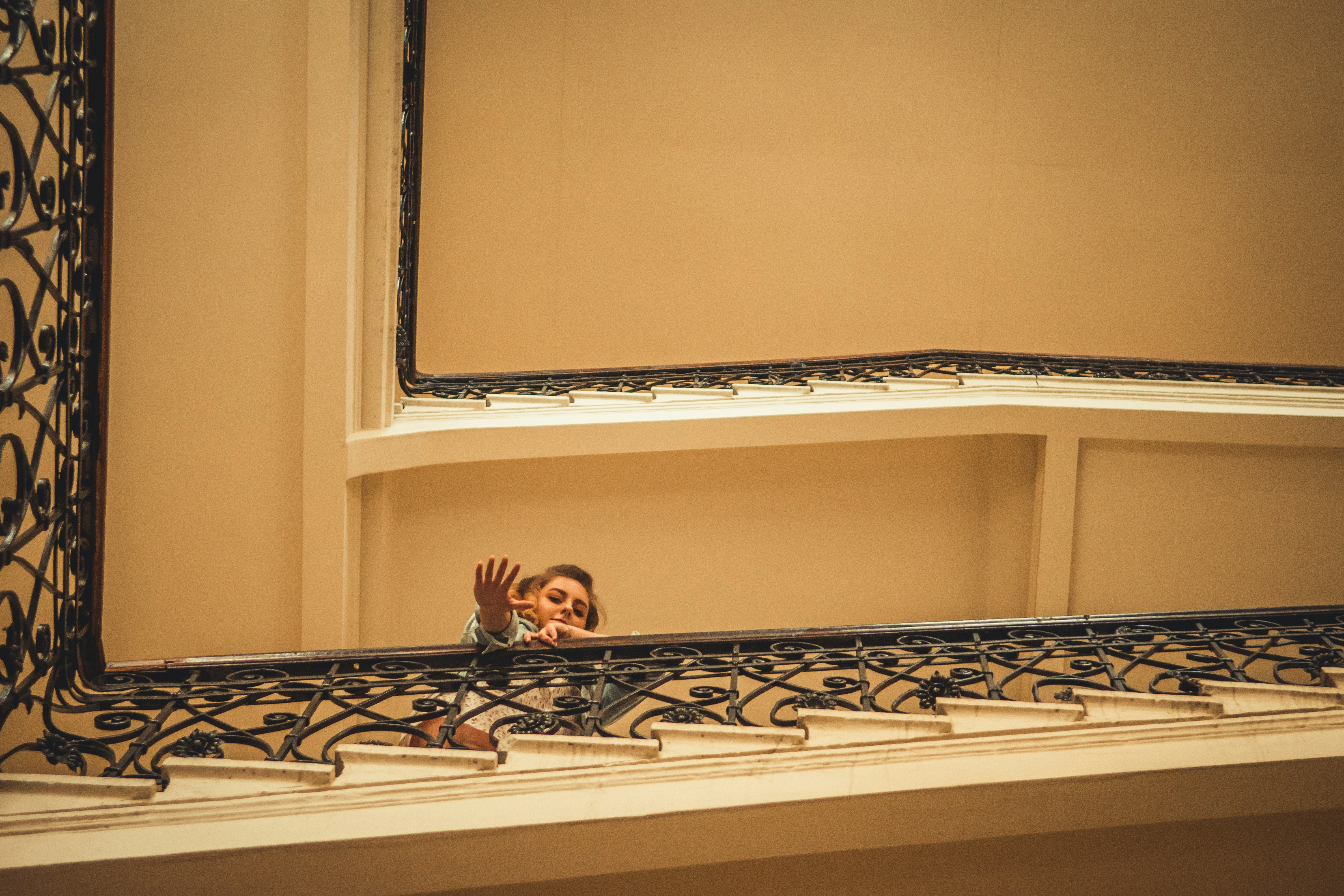 Hello from the Balcony: A Child Waving Through Iron Lace