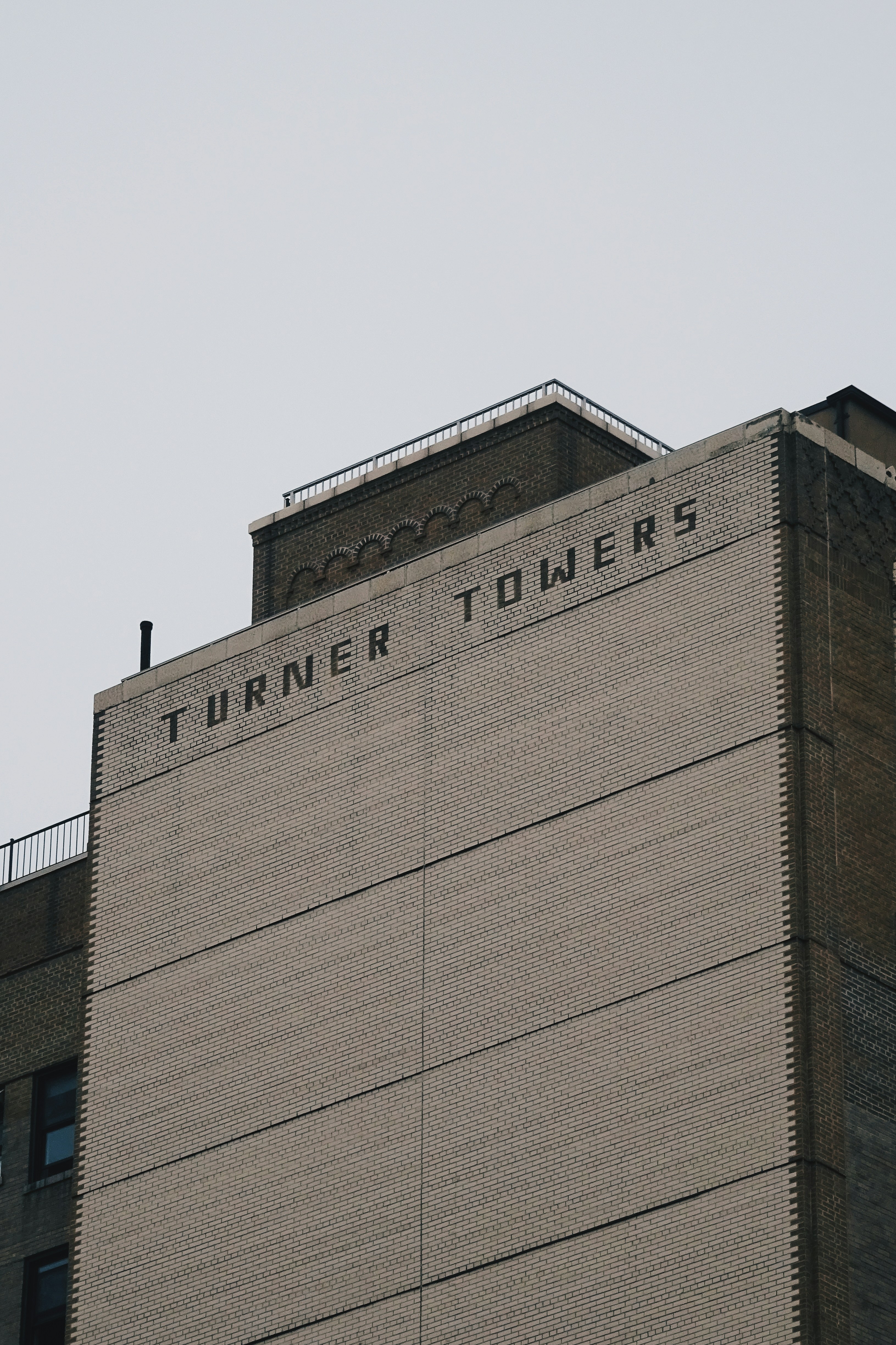 The distinct façade of Turner Towers, showcasing its geometric design and prominent lettering against a muted sky.