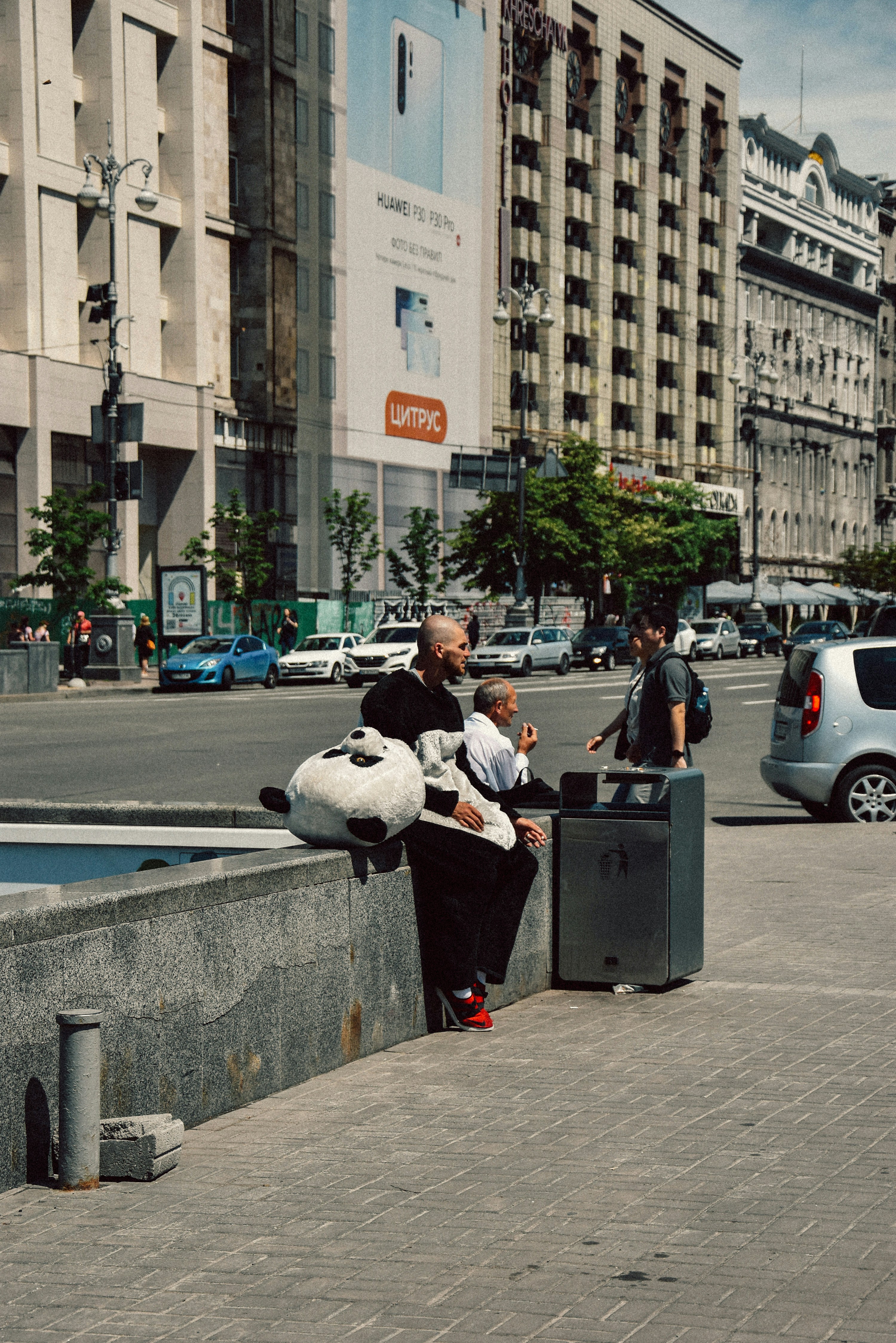 City Street Portrait with a Panda Mascot and Passing Pedestrian
