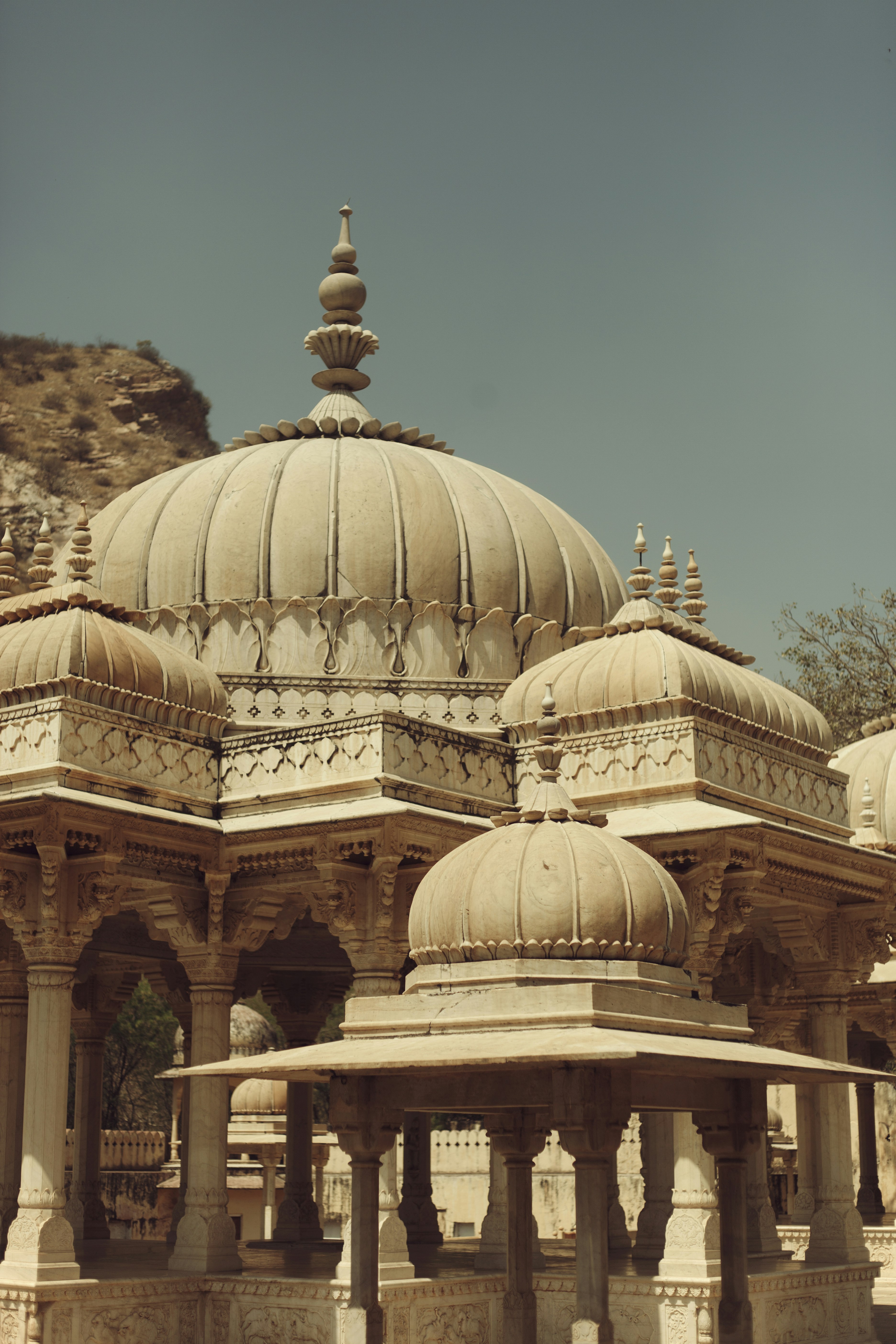 Intricate stone domes of a Jaipur building set against a clear sky.