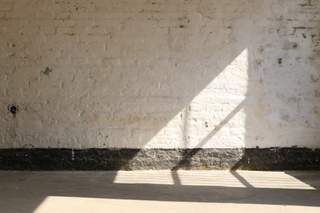 Morning Angles: Striped Light on a Bare Brick Wall