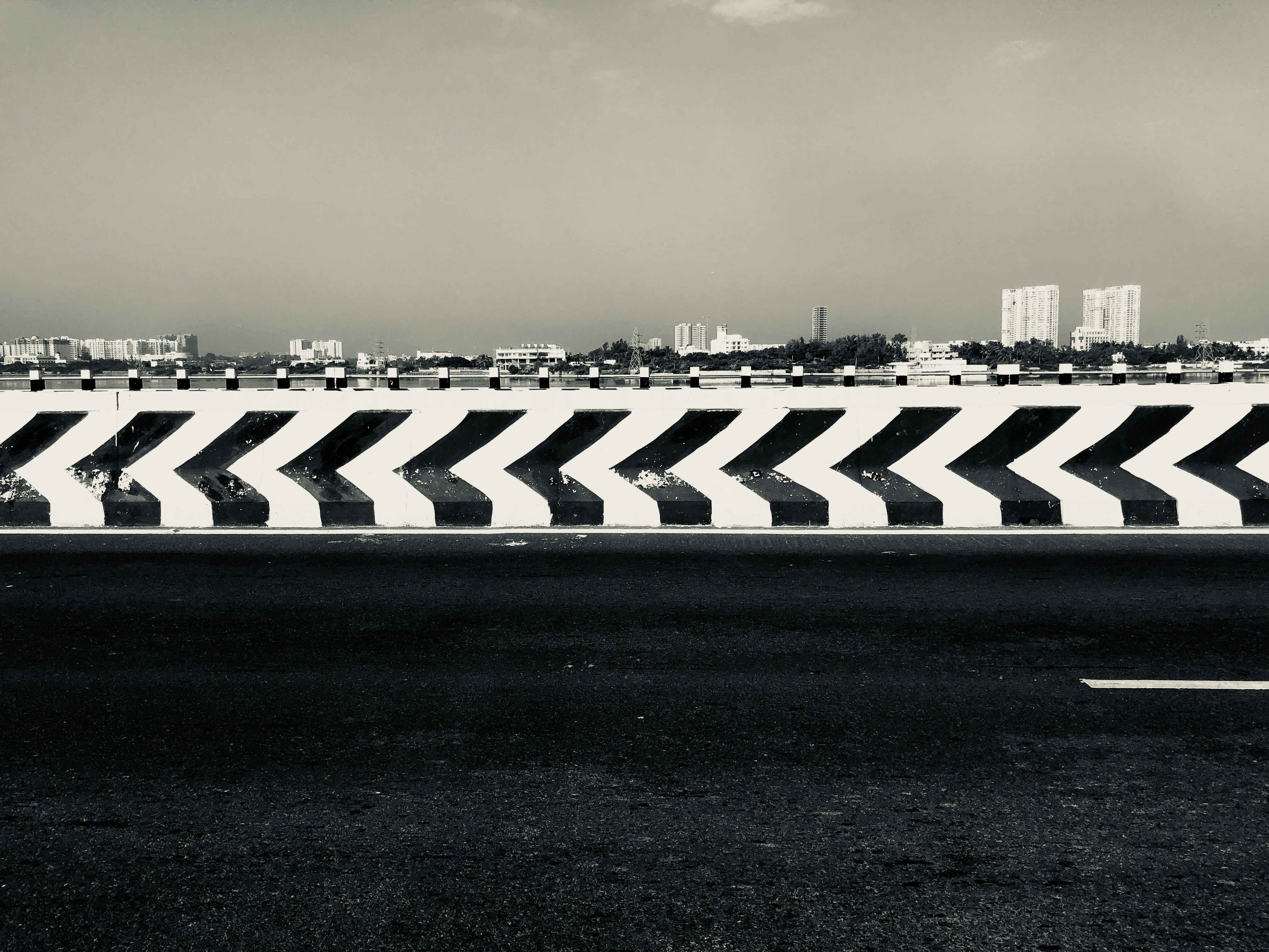 Chevron Echoes: A Monochrome Barrier Framing a Distant City