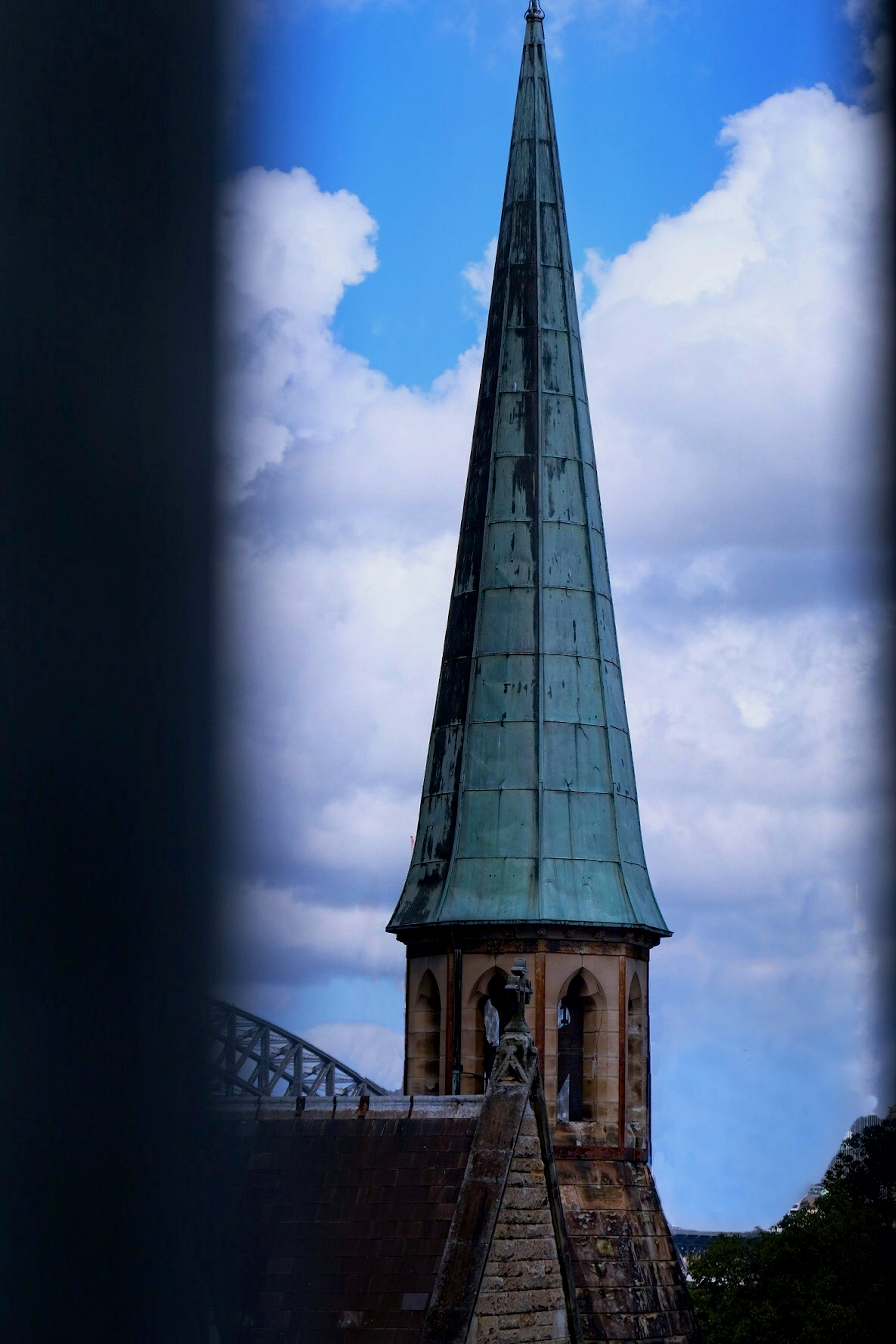 Copper Spire Rising Between Shadowed Edges Under a Blue Sky