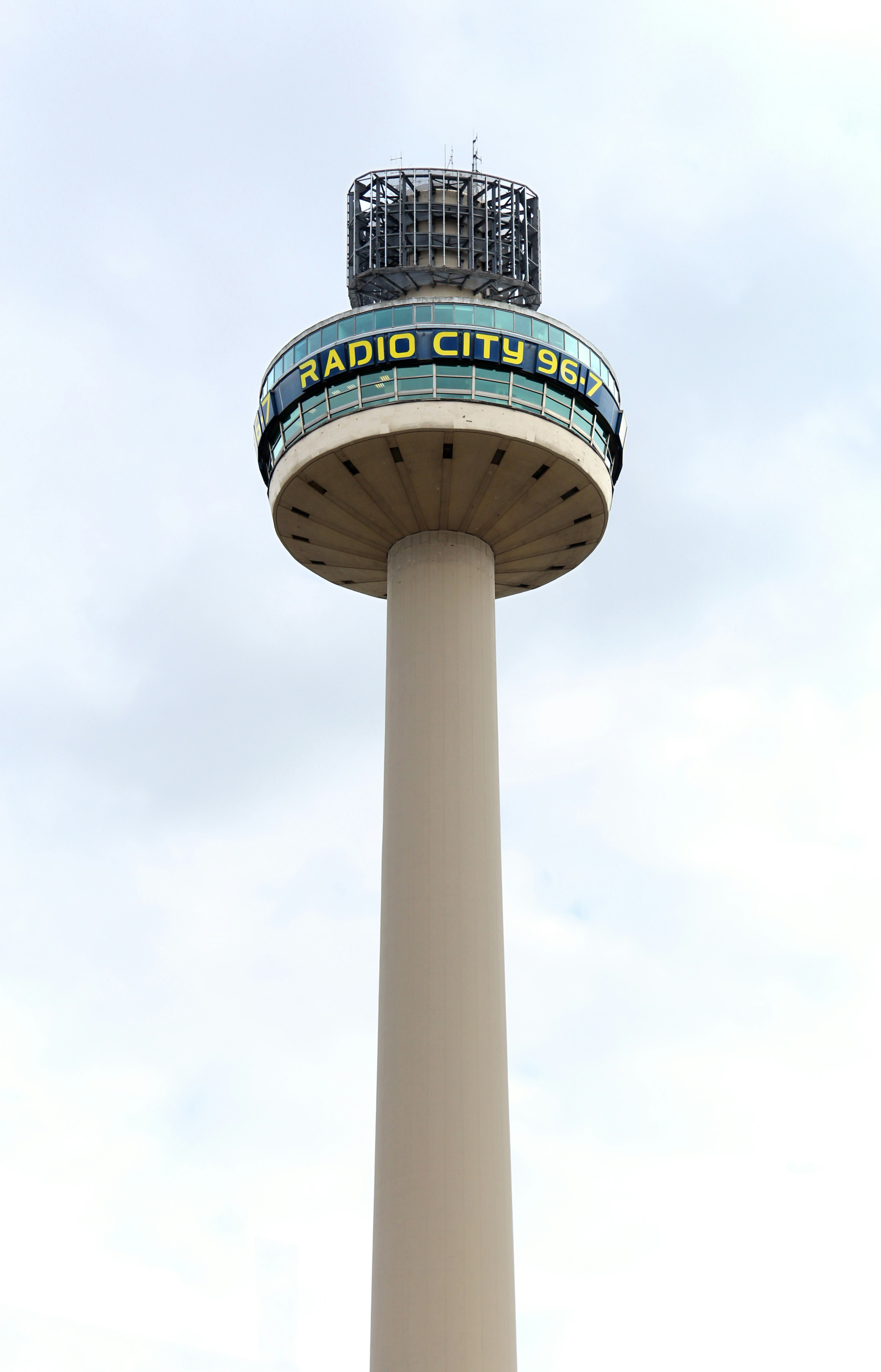 Tall radio tower featuring the 'Radio City 96.7' sign, set against a cloudy sky.