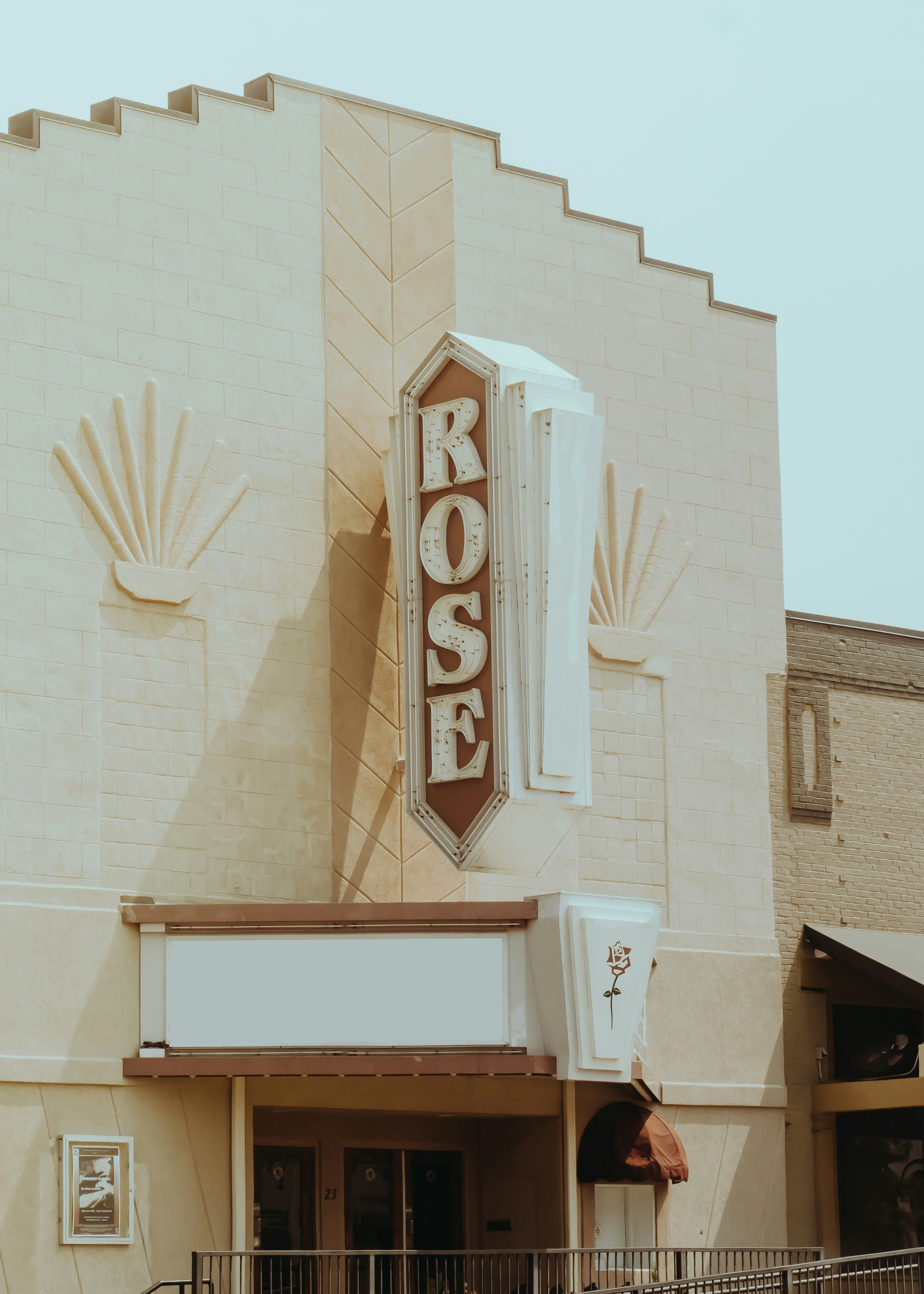Historic theater facade featuring the word 'ROSE' prominently displayed, with elegant architectural details characteristic of the Art Deco style.