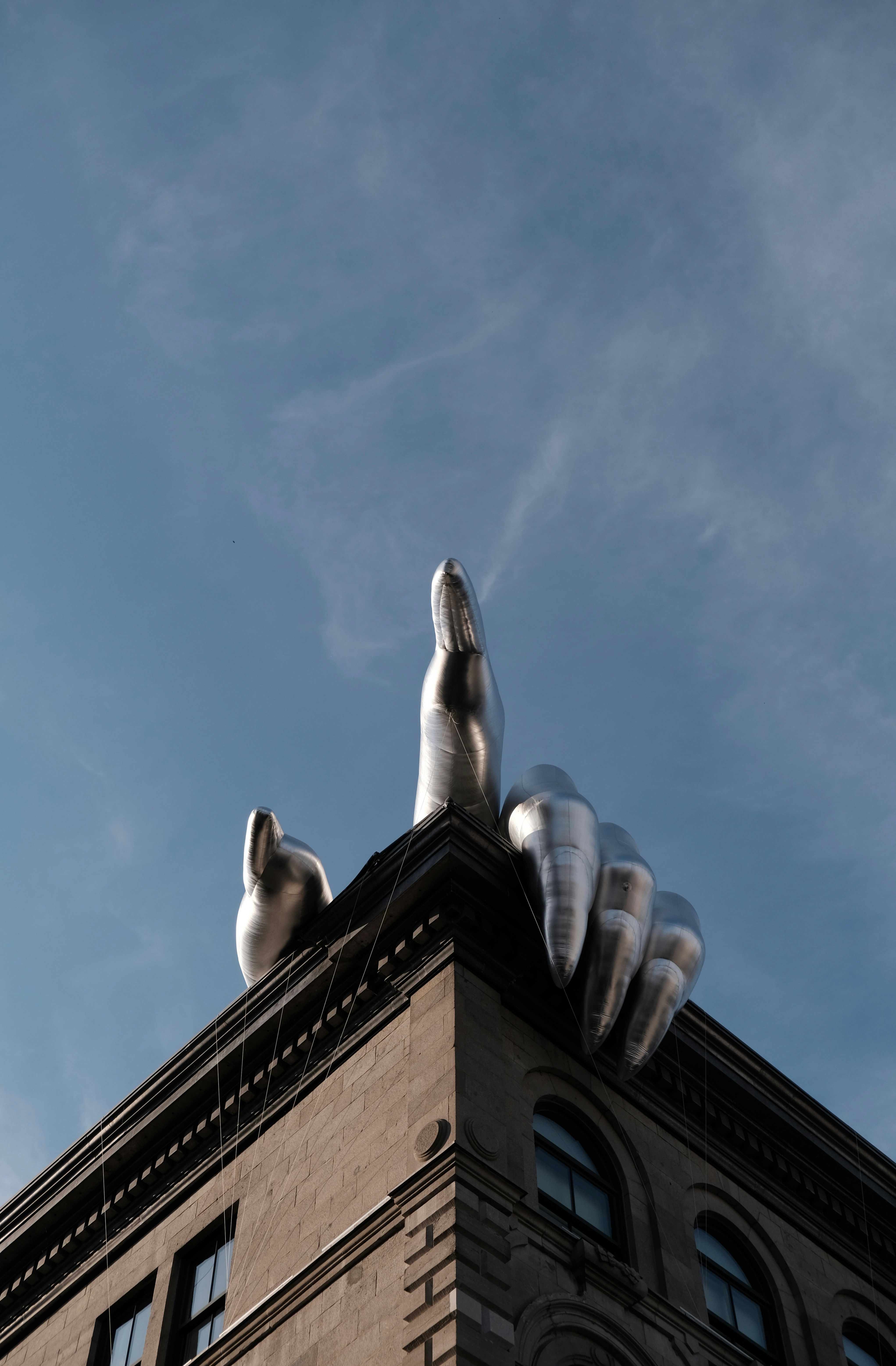 Gargantuan gloved hands crown a cornered city