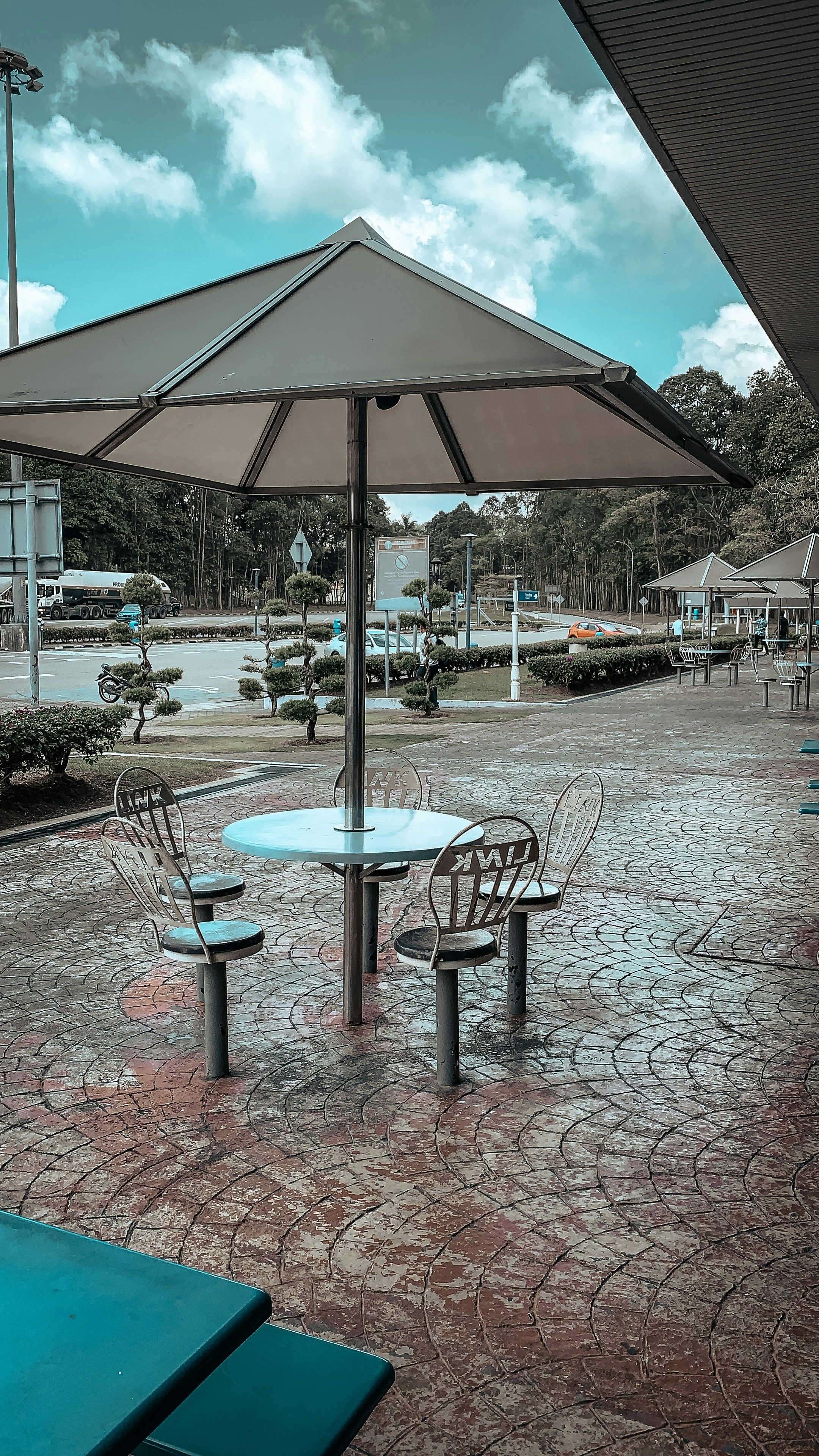 Umbrella shade and turquoise cafe table in a quiet outdoor seating area