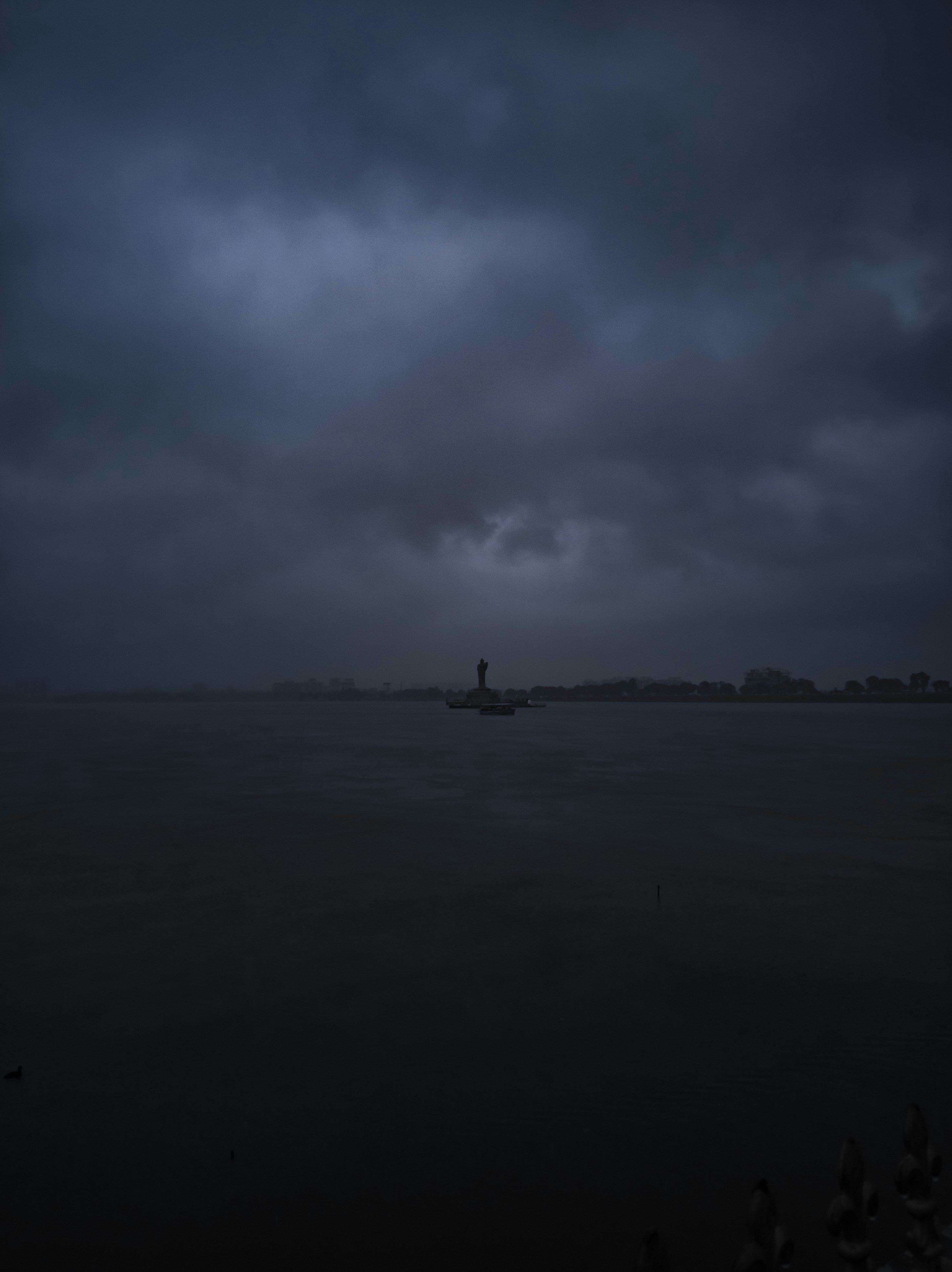 Grey rain clouds looming over the lighthouse at the harbor photo – Free ...