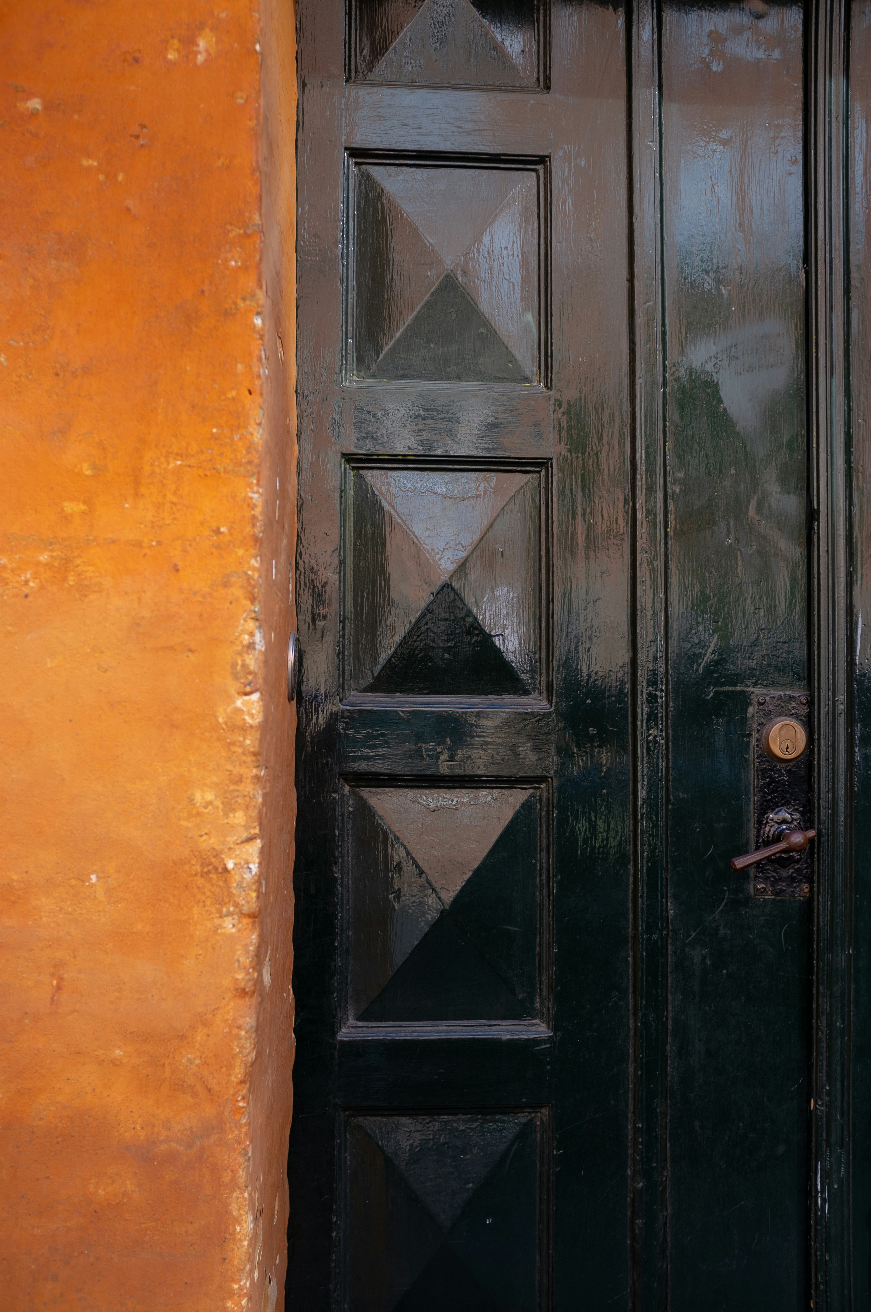 Diamond Panels in a Midnight Door Framed by Ember-Orange Wall