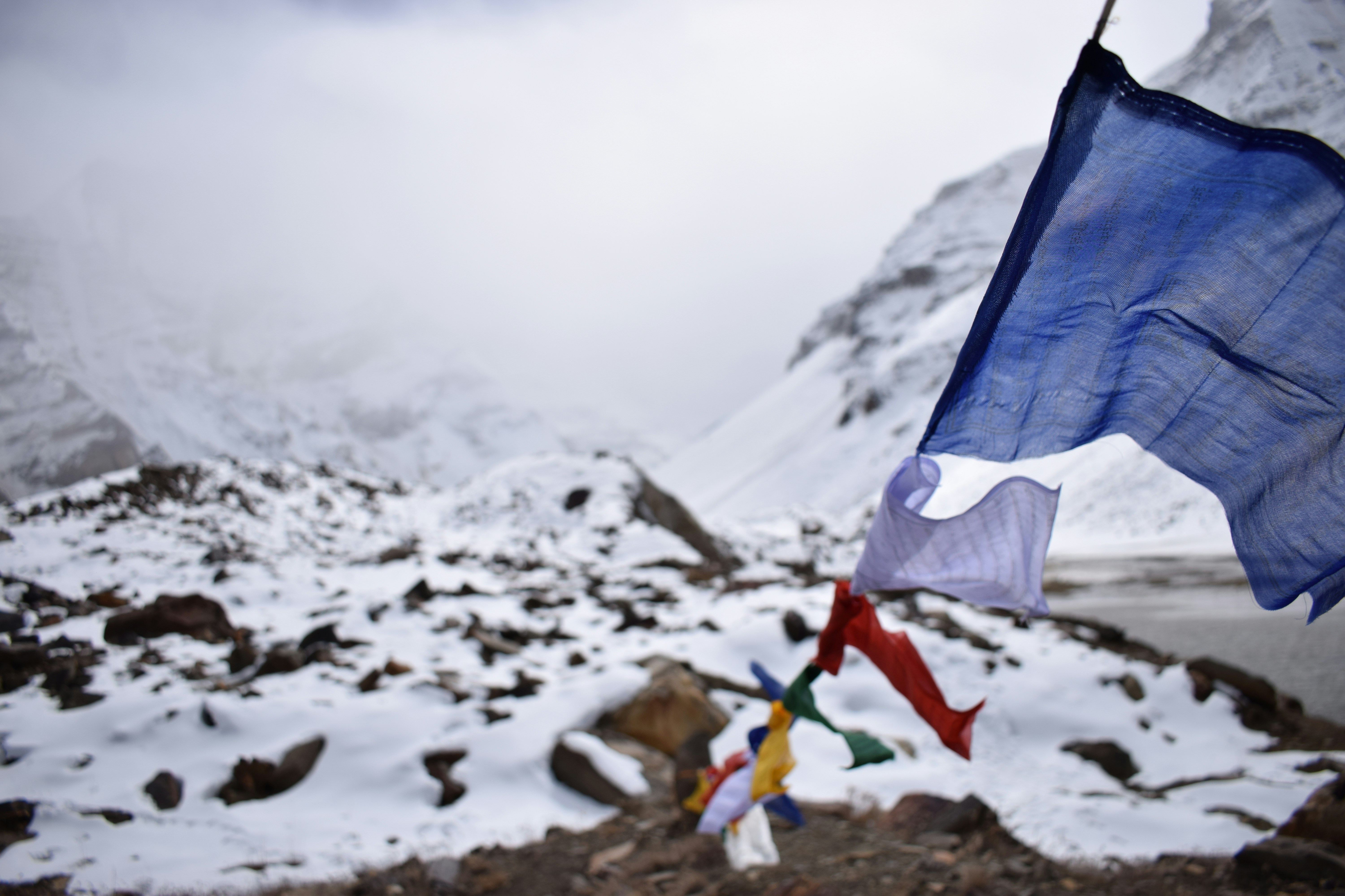 Blue Prayer Flag Fluttering Over a Snowbound Himalayan Pass