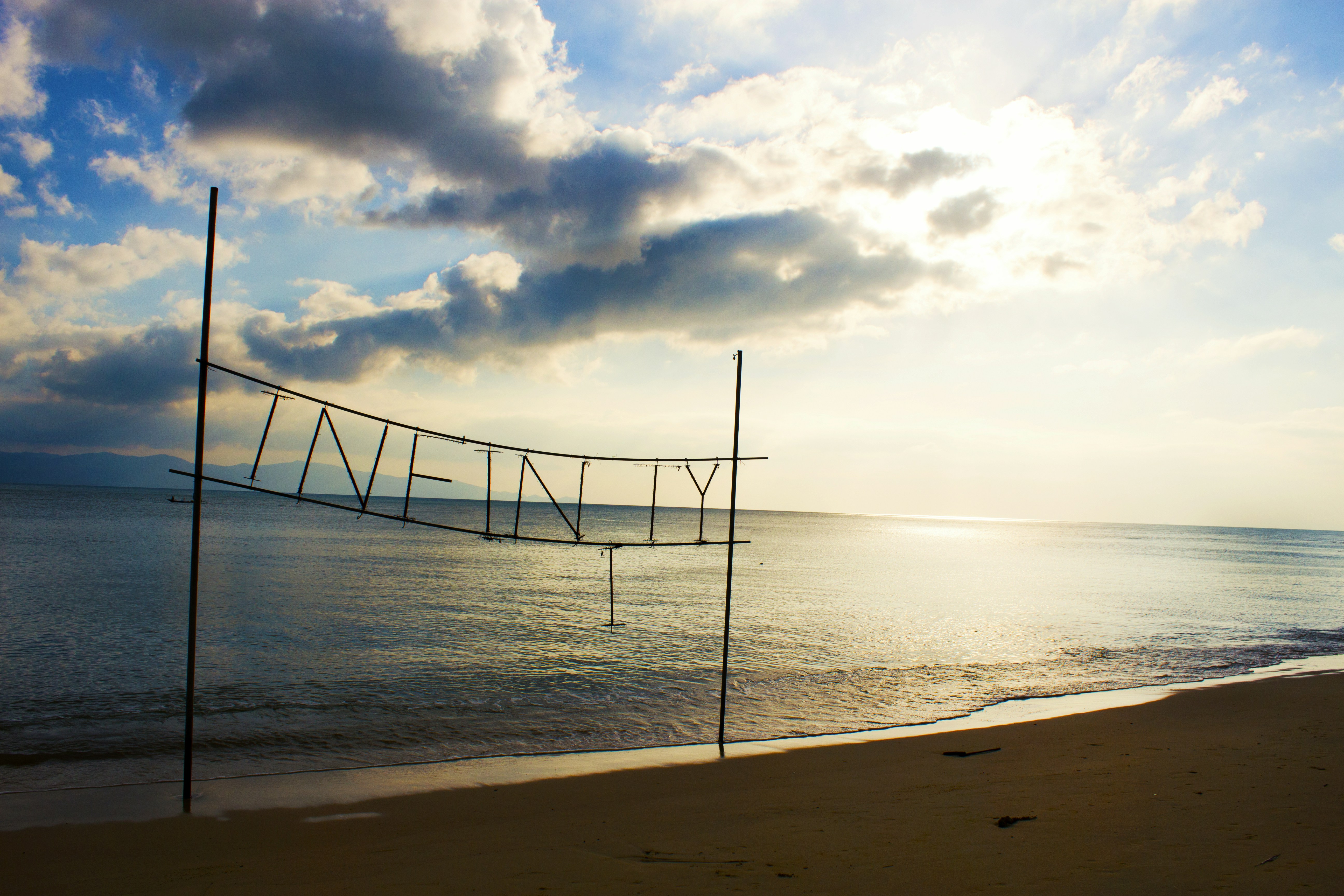 Sunlit beach netscape at the edge of calm waters