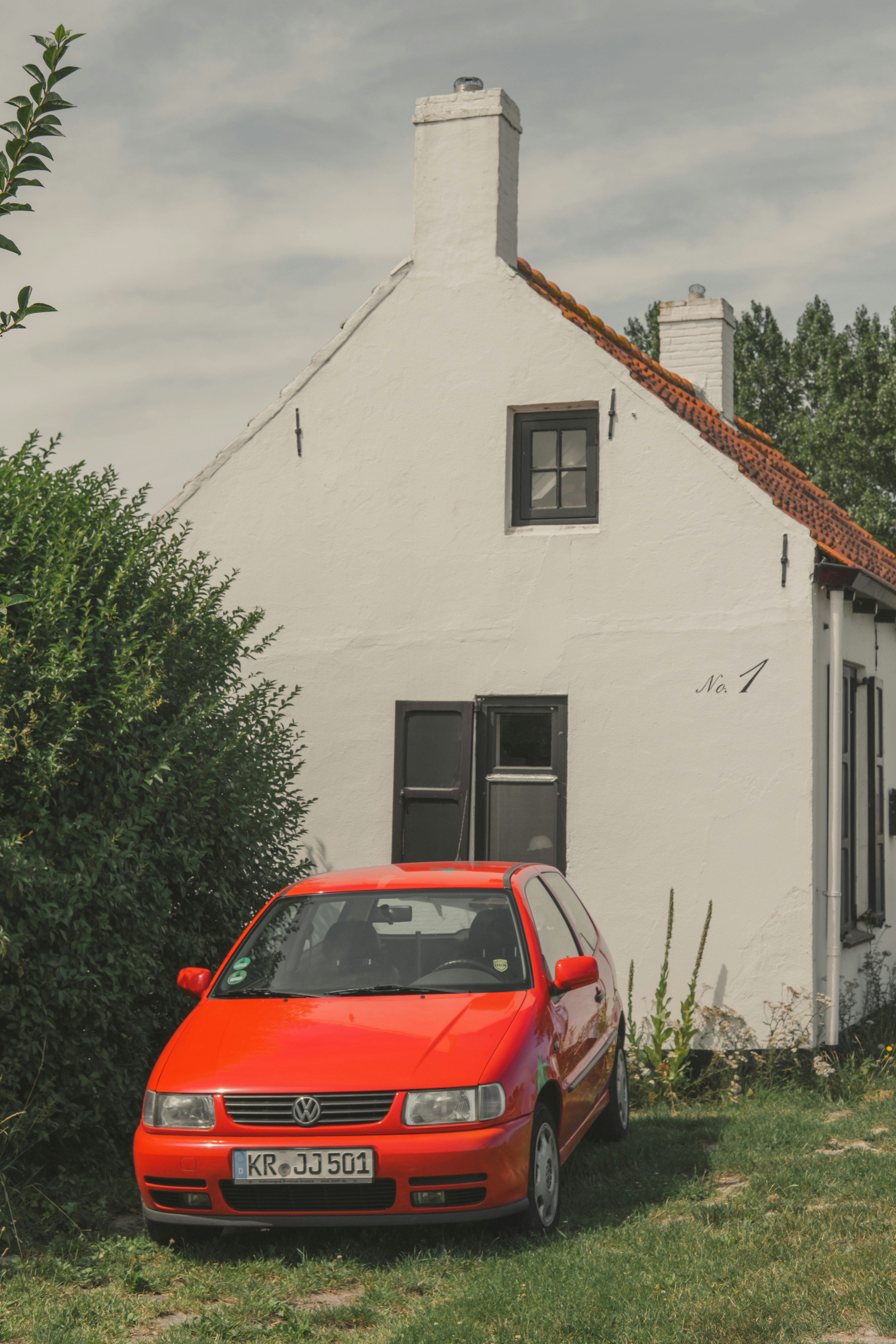 Crimson VW Beside a Sun-Washed Cottage