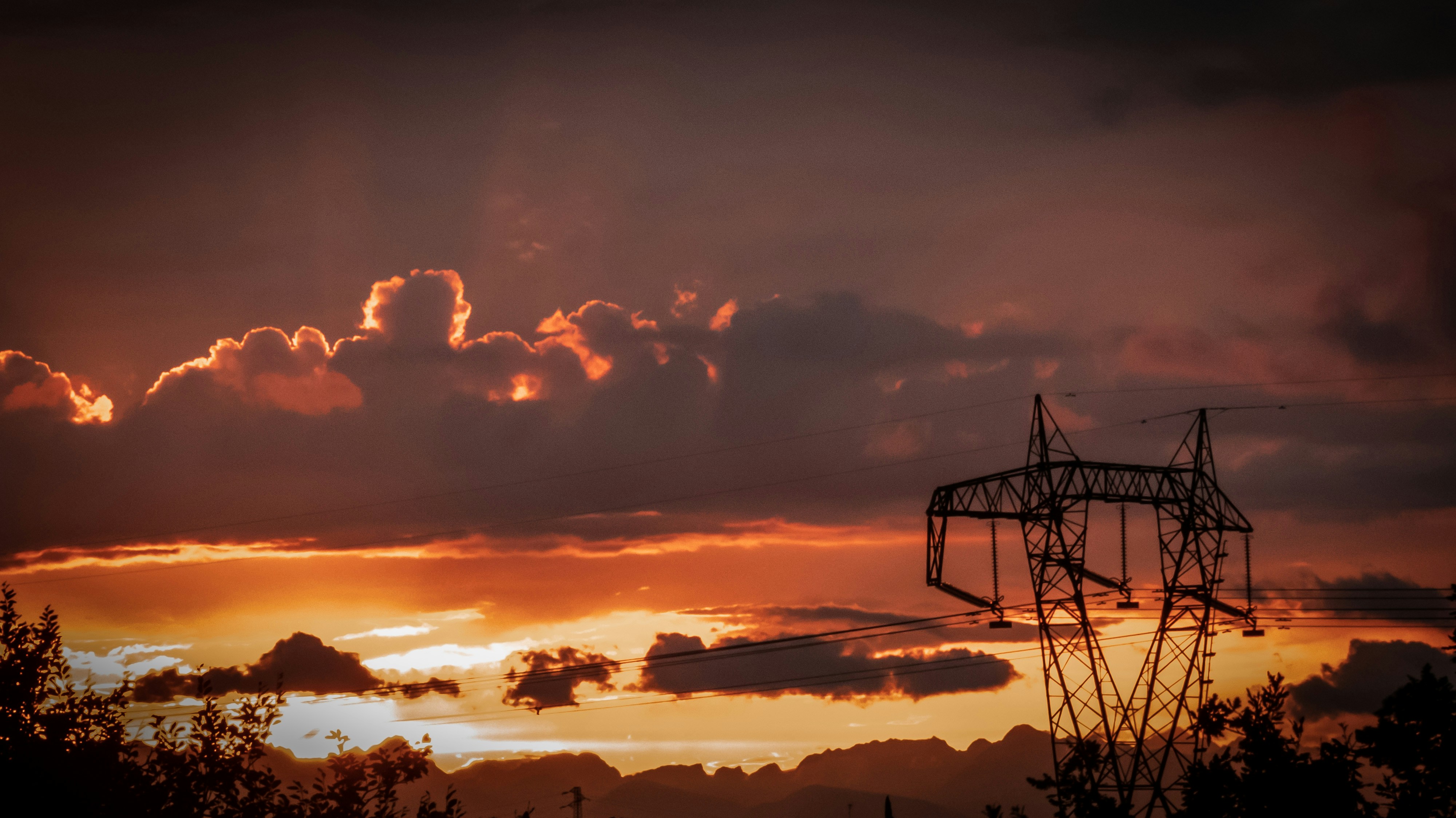 Crimson Dusk: Framing a Fiery Sunset with a Transmission Tower