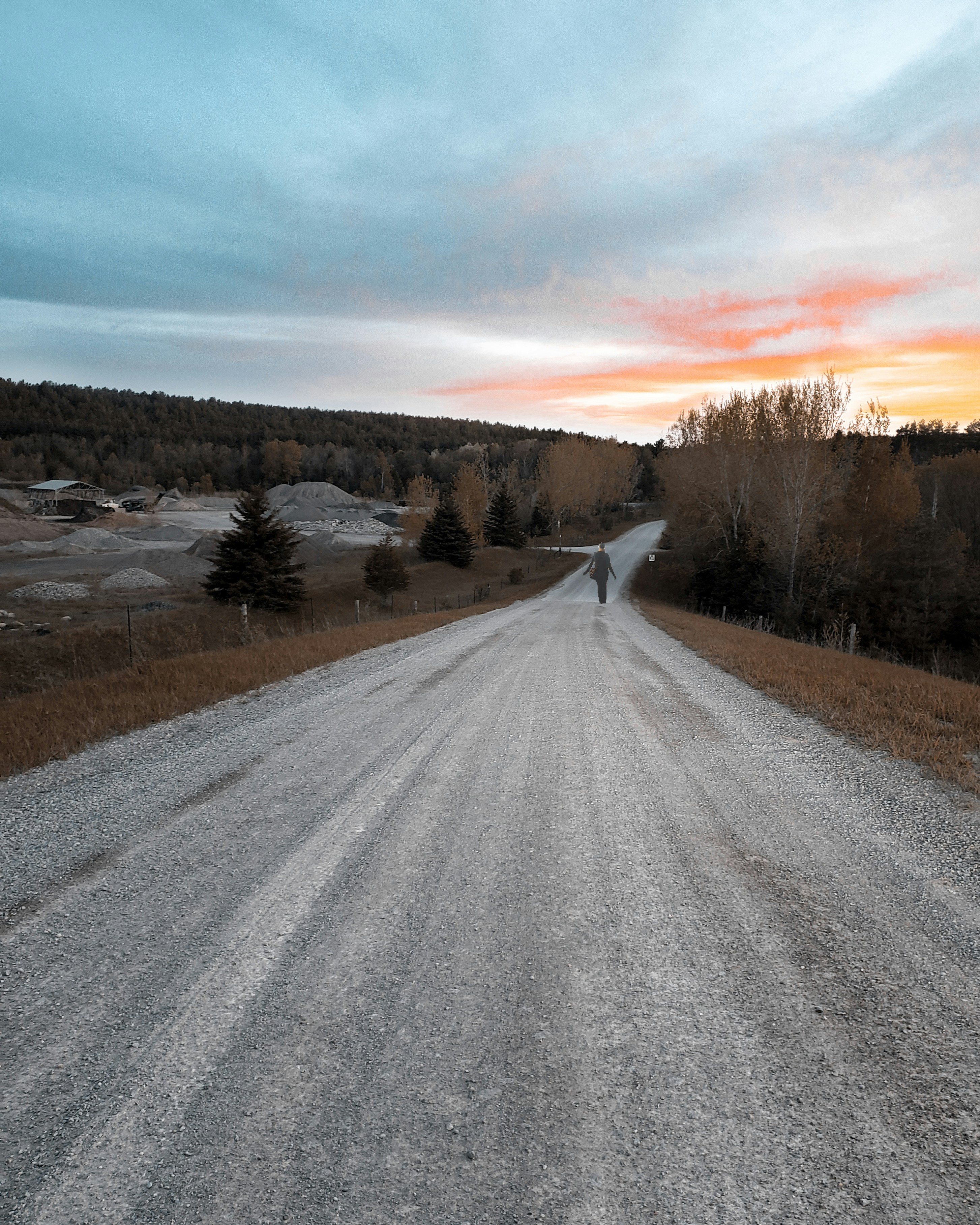 Evening Gravel Lane: A Lone Figure and the Quiet Horizon
